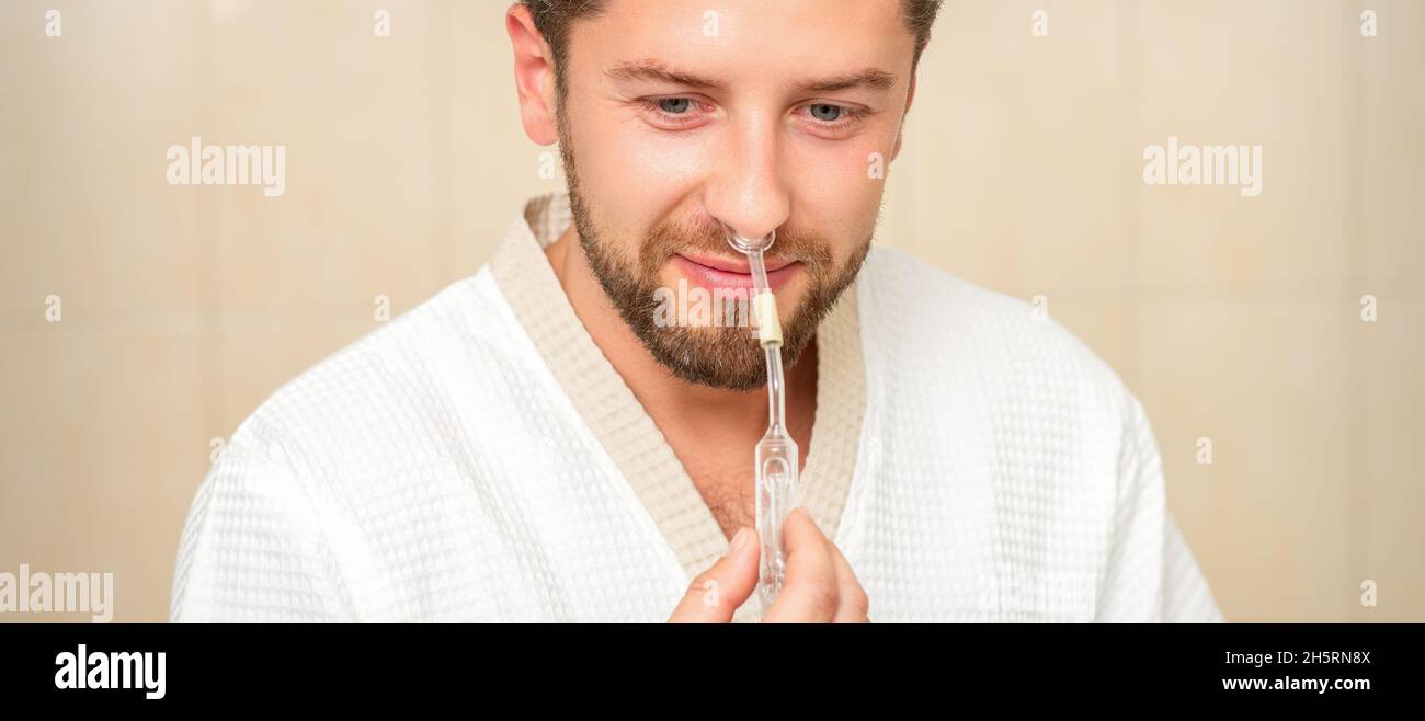 Young caucasian man receiving nasal inhalation Maholda with essential ...