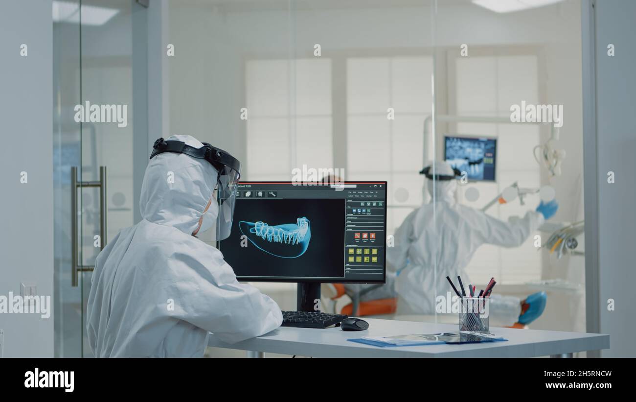 Orthodontists analyzing virtual teeth animation at oral clinic desk ...