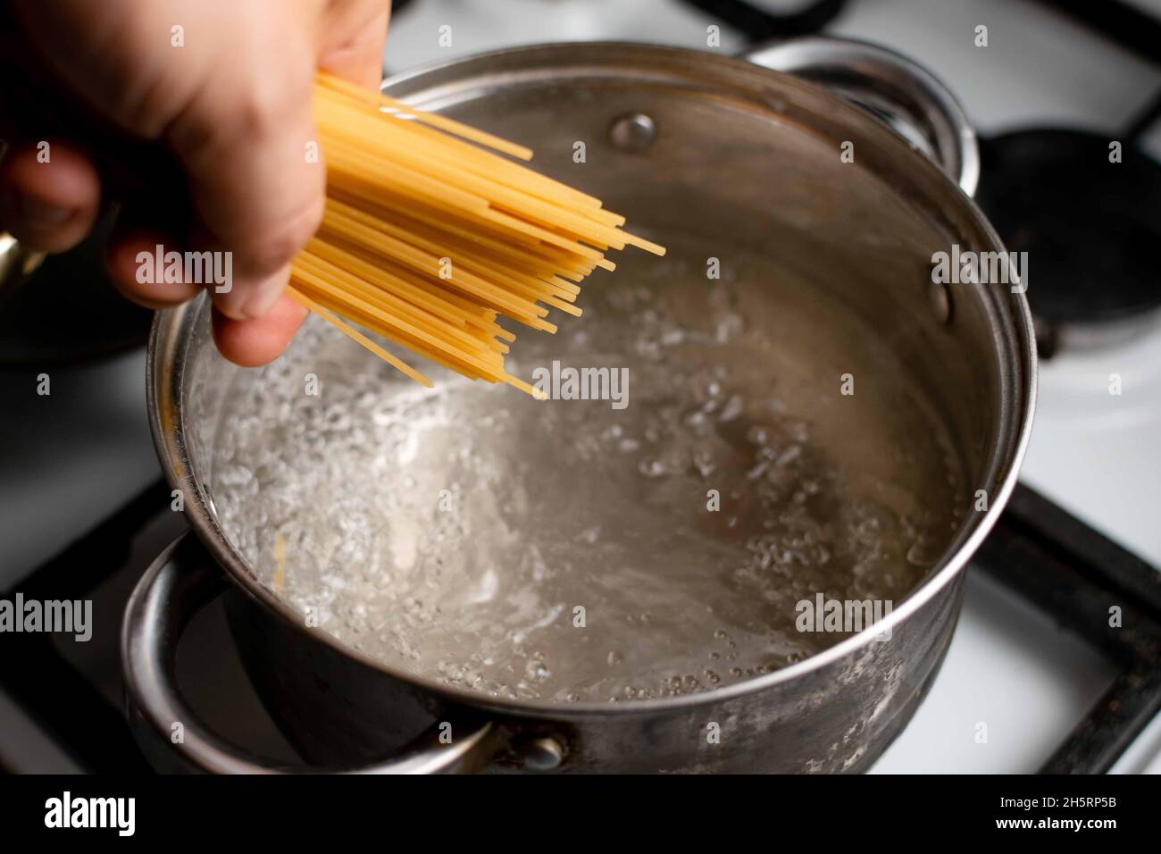 Pasta cooking hand pot kitchen hi-res stock photography and images - Alamy