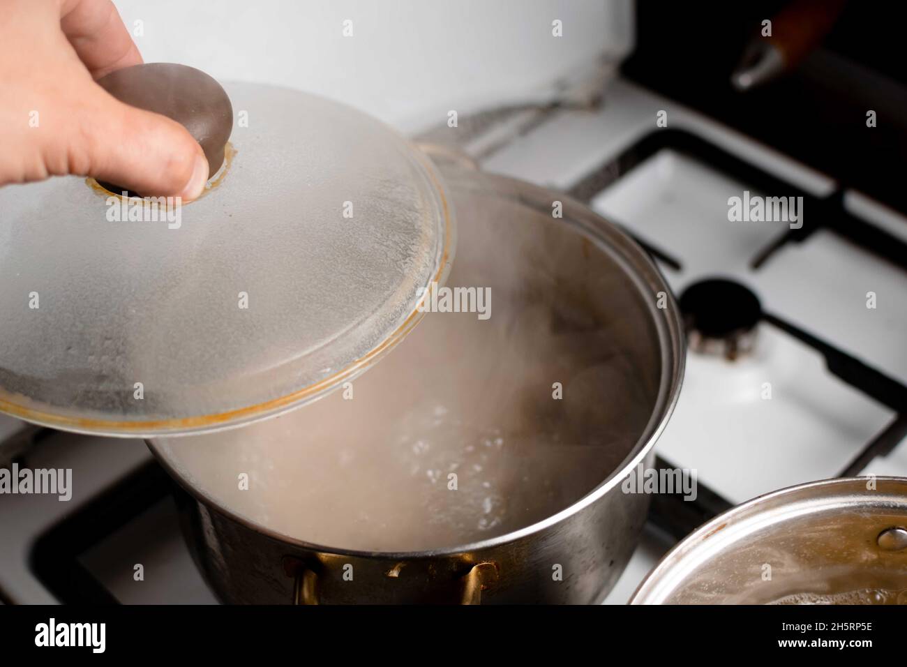 An old saucepan with boiling water and an open lid Stock Photo - Alamy