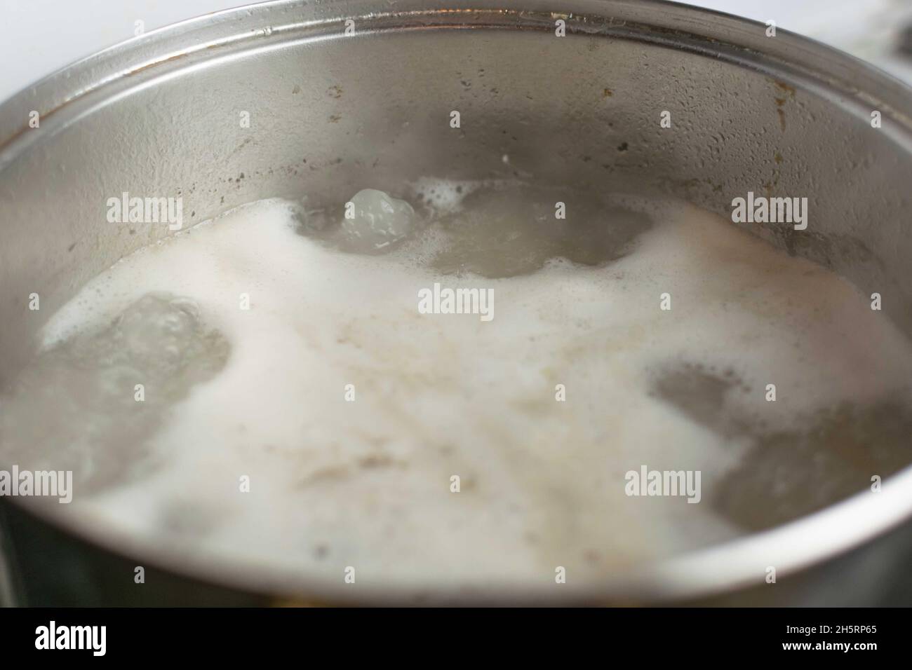 Foam in a boiling pot while cooking broth Stock Photo - Alamy