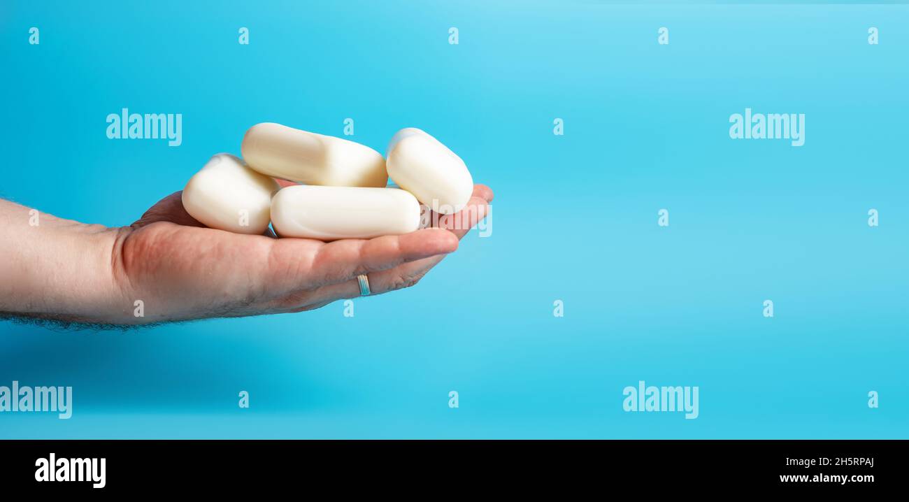 Global Handwashing Day. Bars of soap in a man's hand on a blue ...