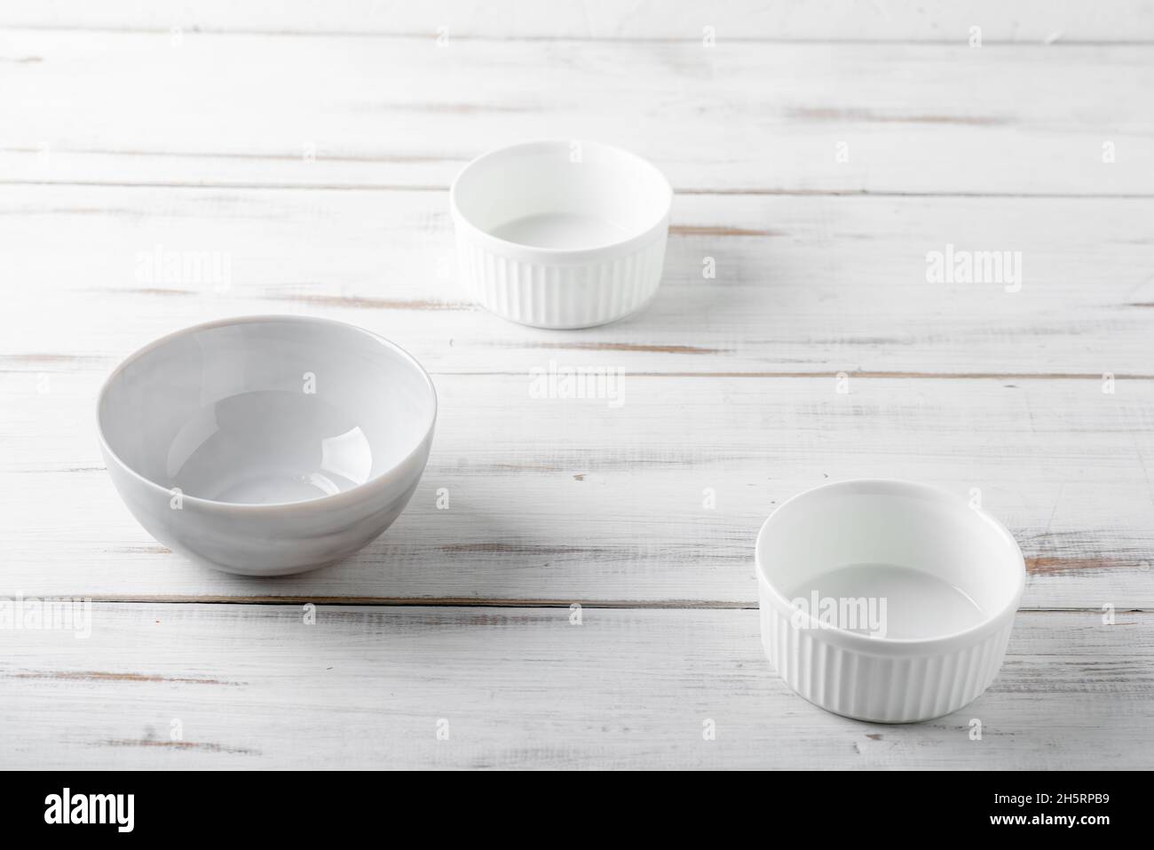 Empty assorted plates on a white wooden background. Table setting Stock ...