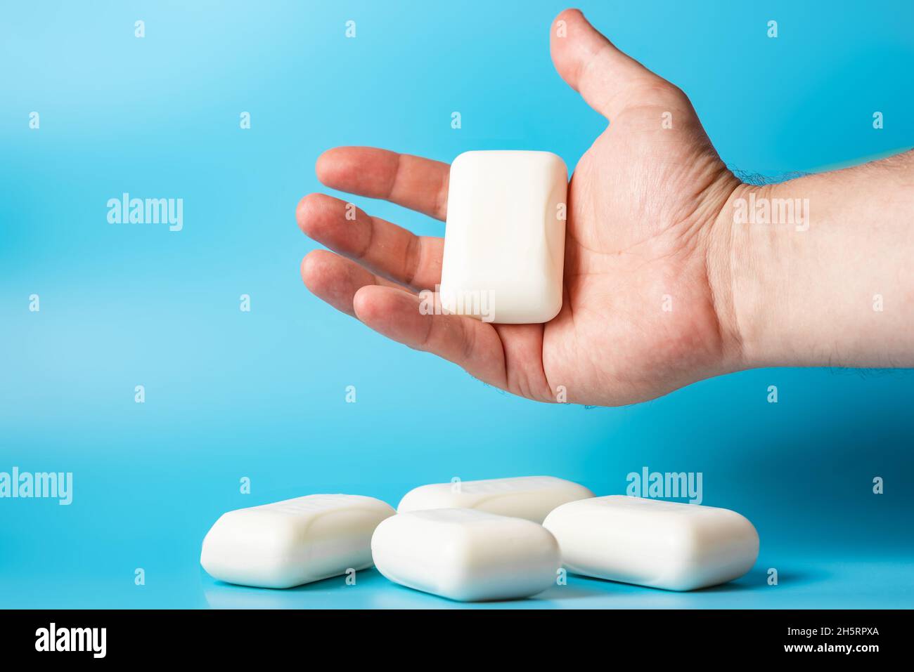 Global Handwashing Day. A bar of soap in a man's hand on a blue ...