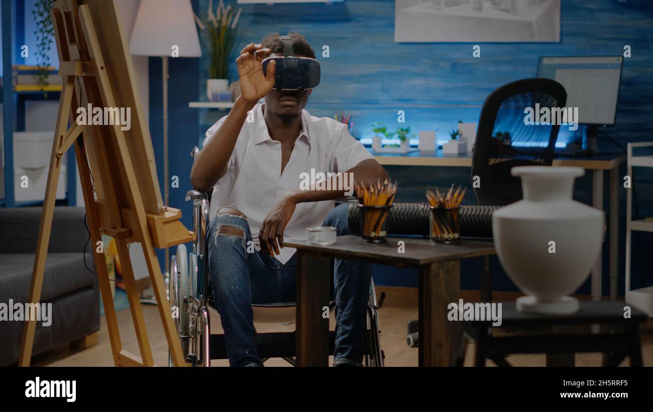 Disabled black artist using vr glasses for virtual inspiration on drawing project at studio ...