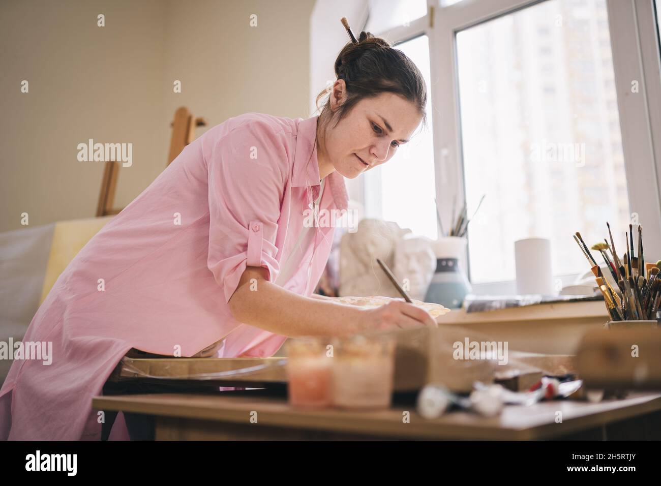 Female artist working in studio. Creative workspace, painting class ...