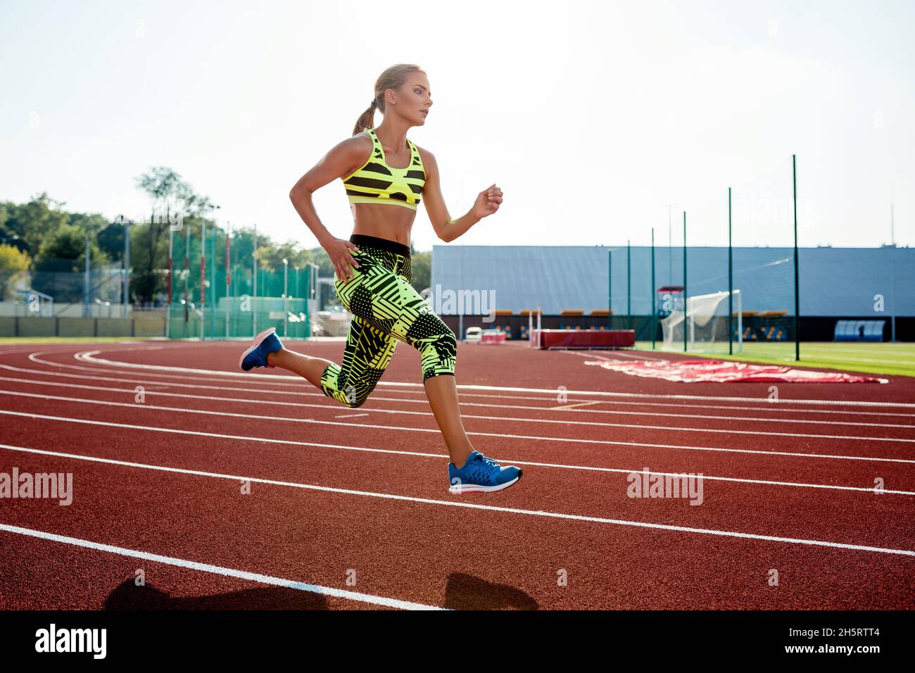 Beautiful young woman exercise jogging and running on athletic track on ...