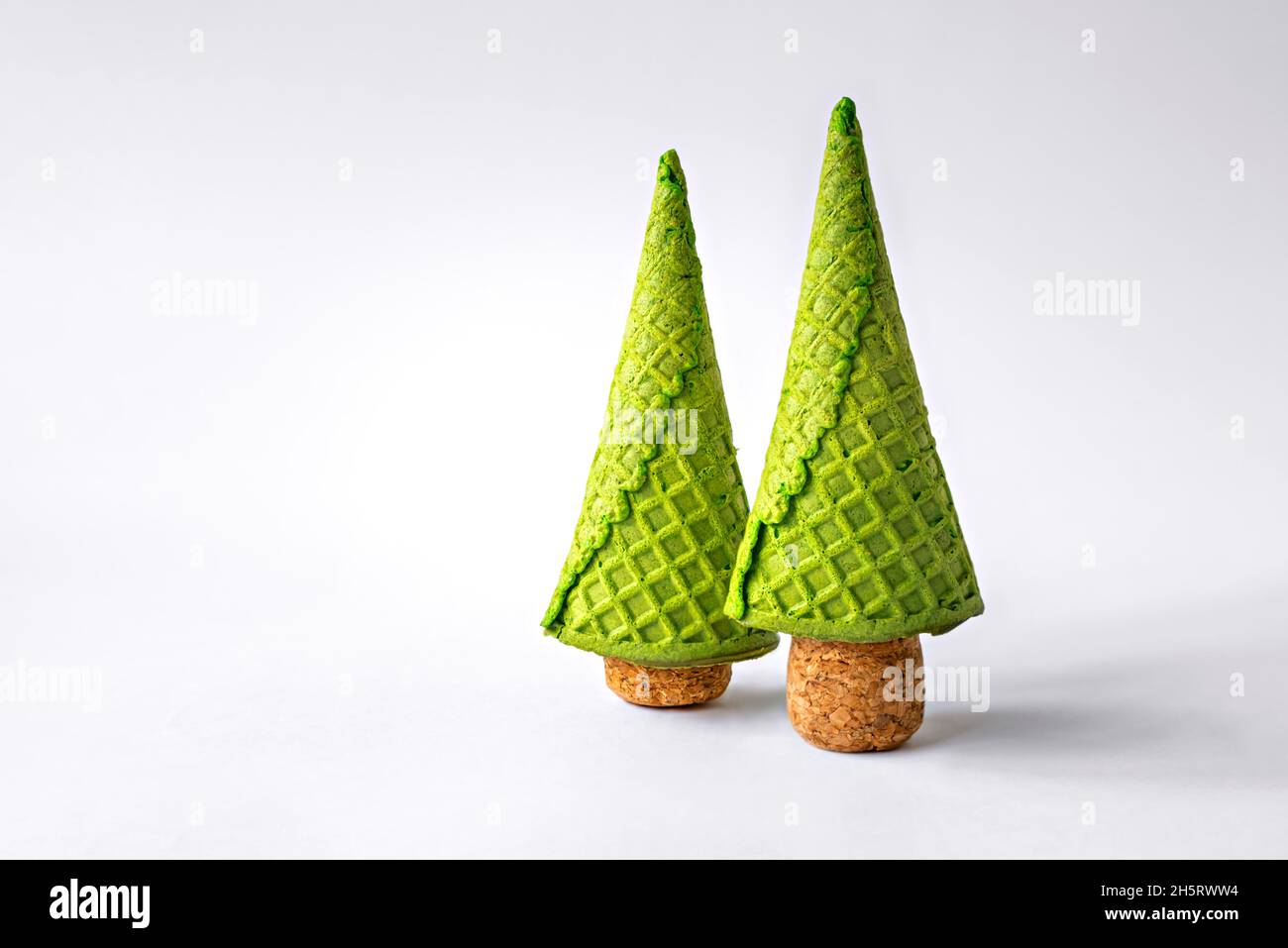 Two Christmas trees made of waffle cones and champagne corks on a white ...