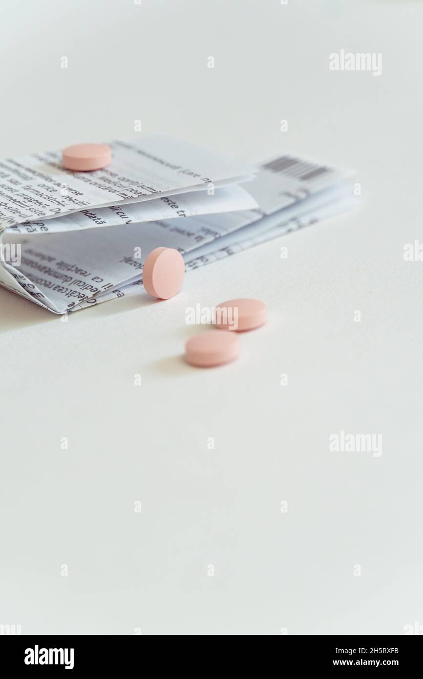 Vertical shot of medical pills with a medication guide isolated on a ...