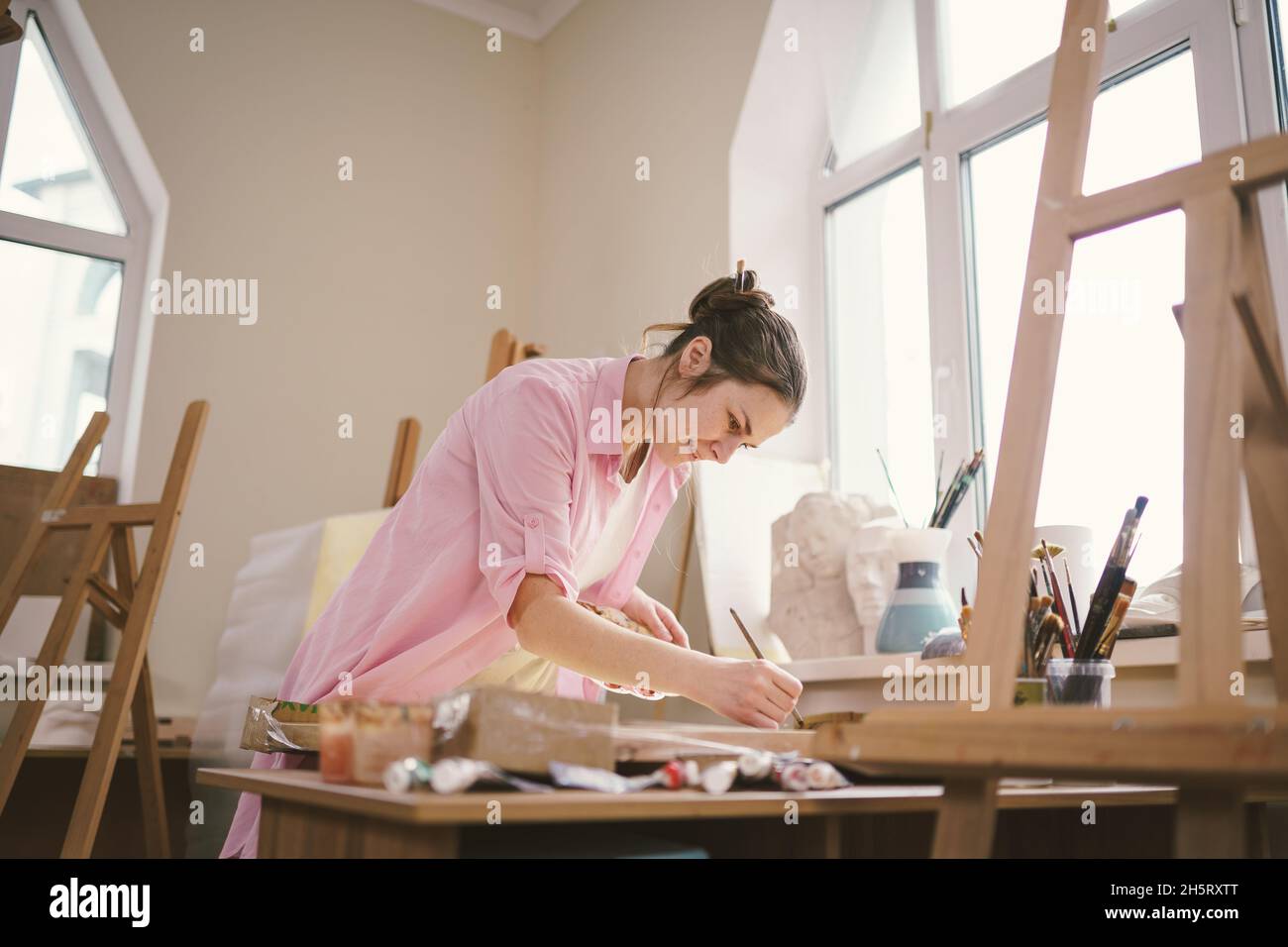 Female artist working in studio. Creative workspace, painting class ...
