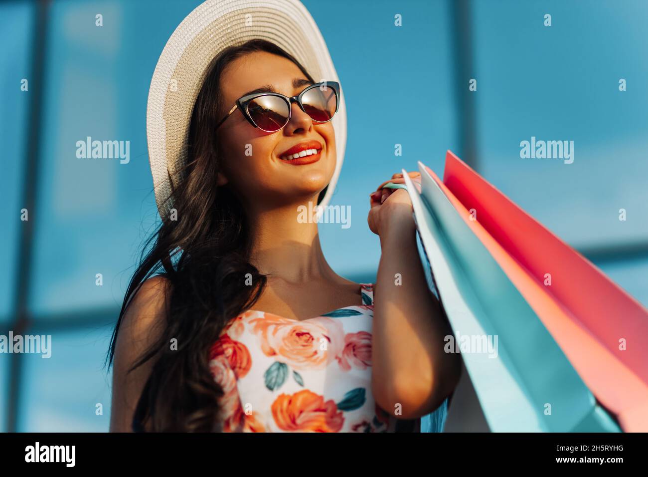 Stylish woman with shopping bags walks through the city streets ...