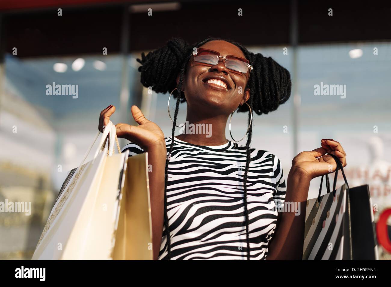 Happy beautiful black woman with shopping bags having fun in the city ...