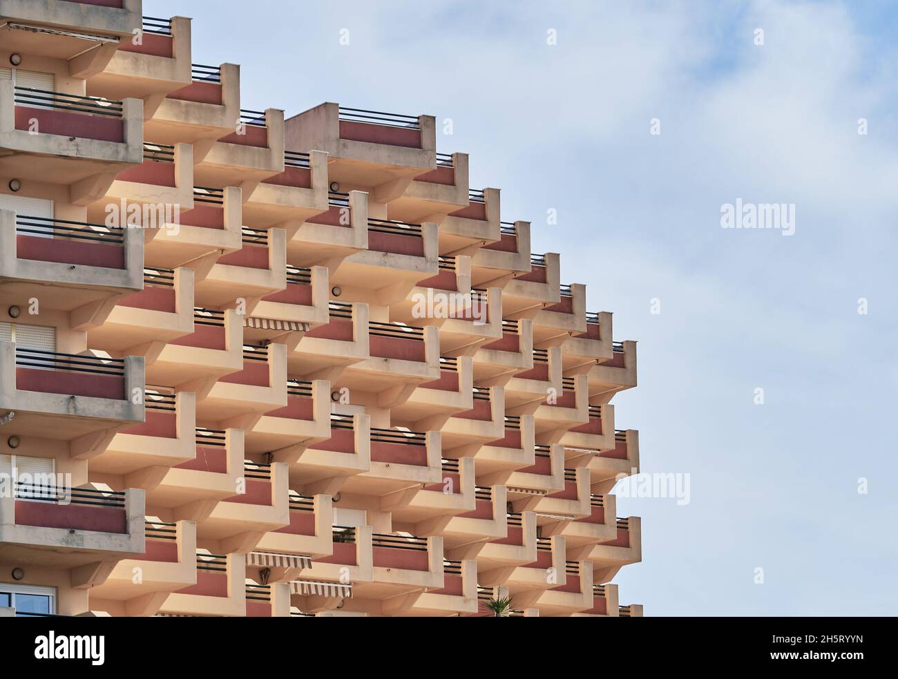 stair stepped vacation building with balconies and windows with blue ...