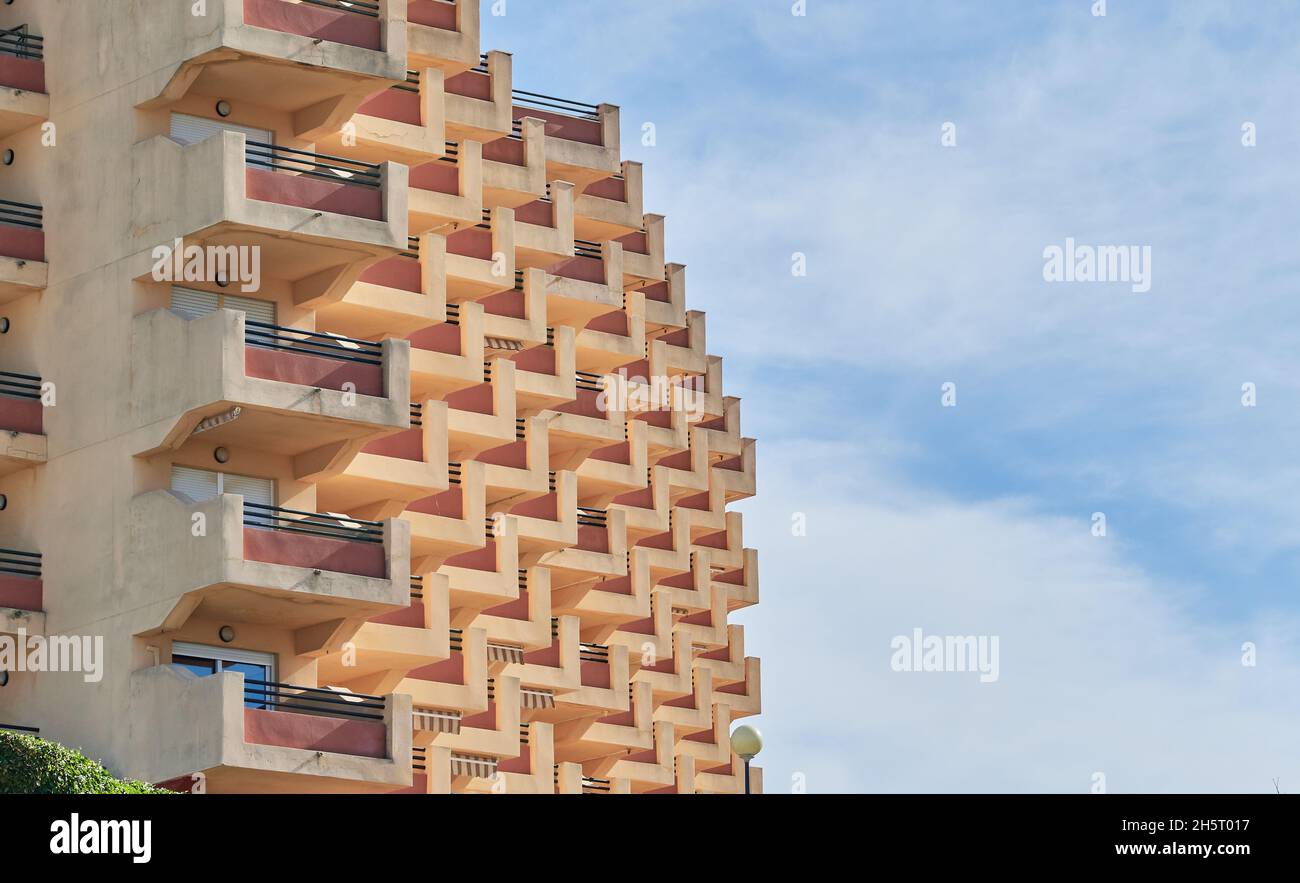 stair stepped vacation building with balconies and windows with blue ...