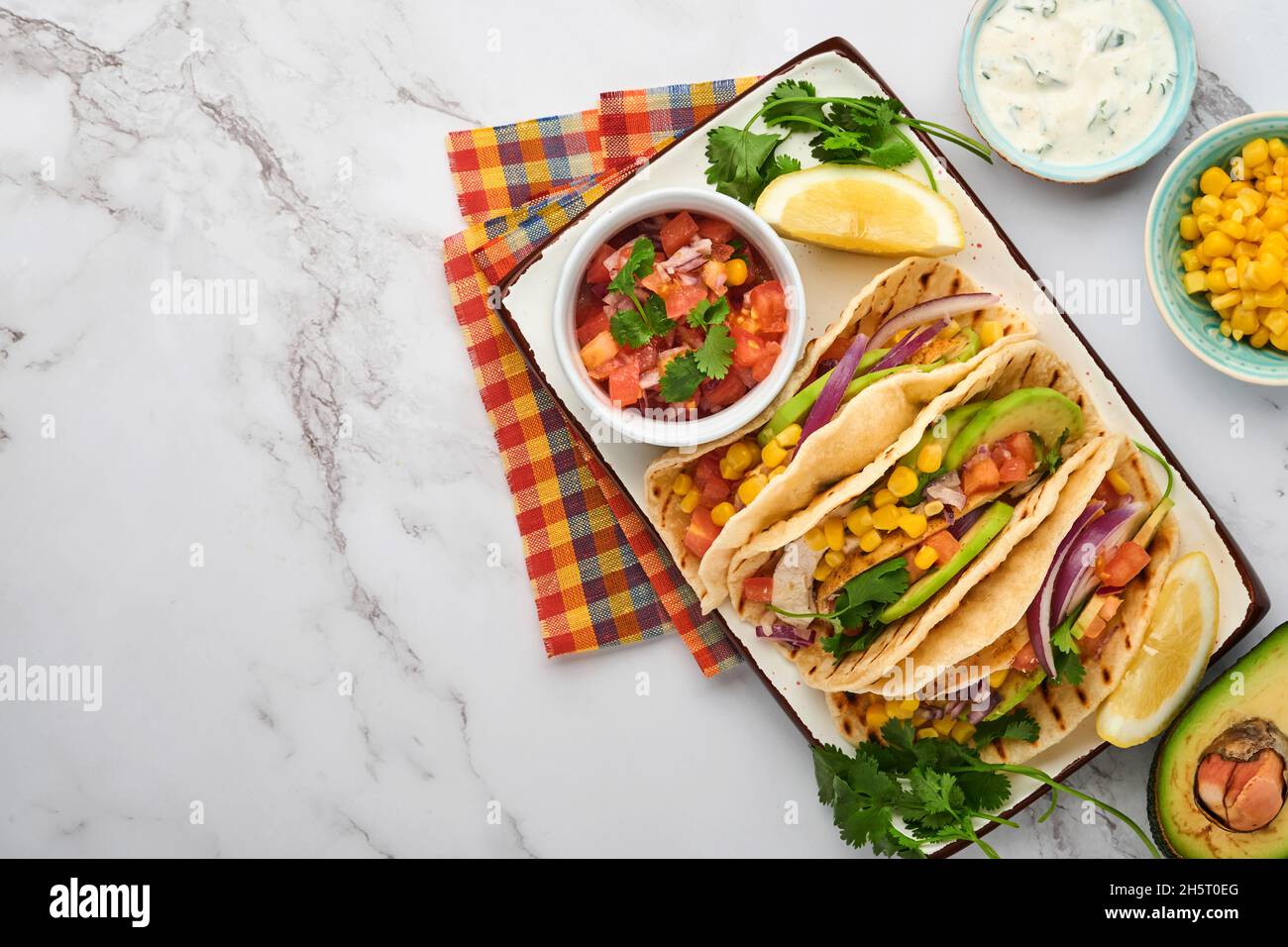 Mexican tacos with grilled chicken, avocado, corn kernels, tomato ...