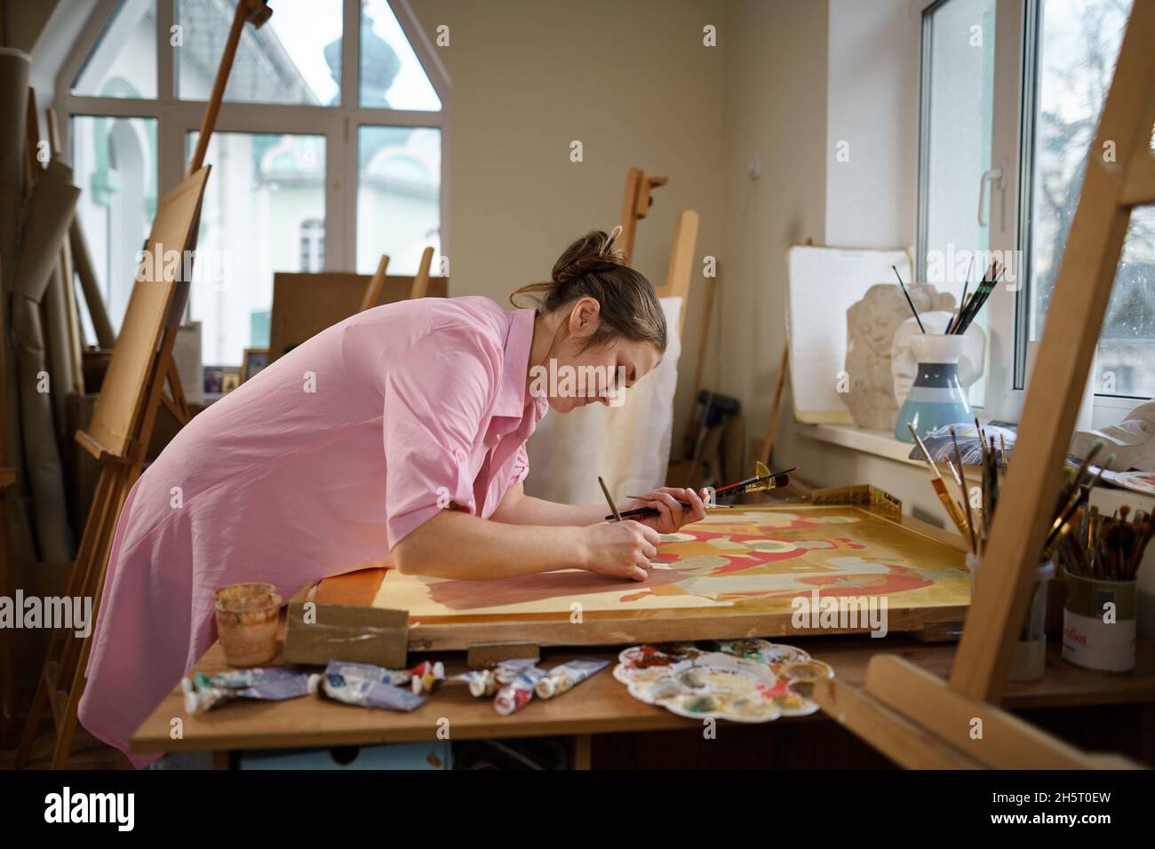Female artist working in studio. Creative workspace, painting class ...
