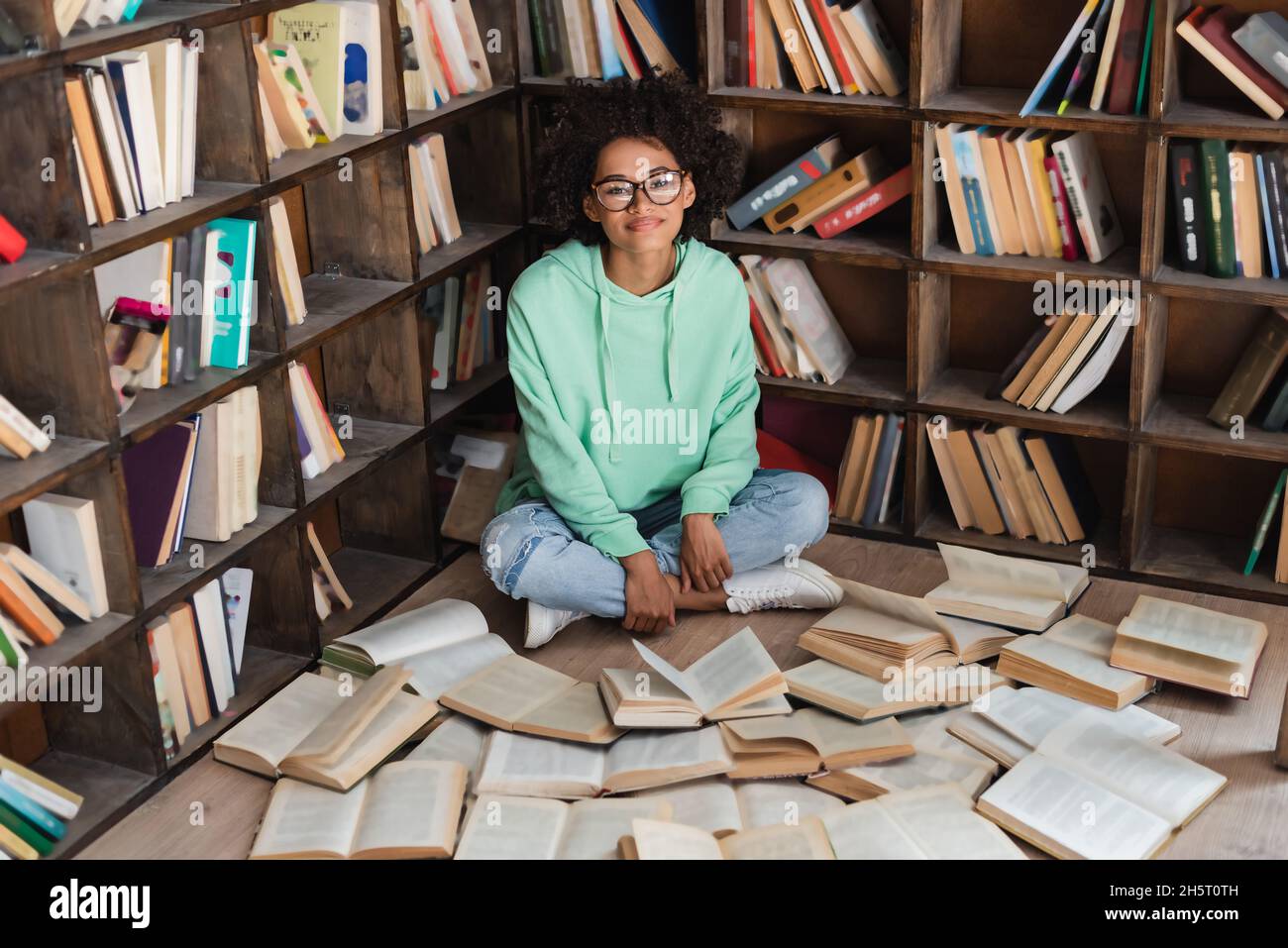 Young woman surrounded books in hi-res stock photography and images - Alamy