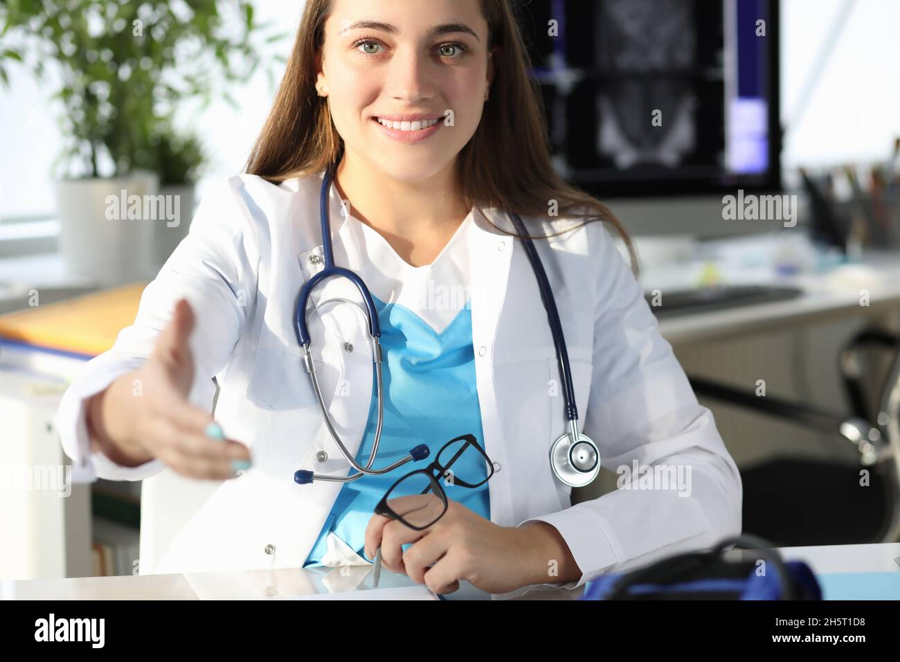 Woman doctor giving hand for handshake in clinic Stock Photo - Alamy