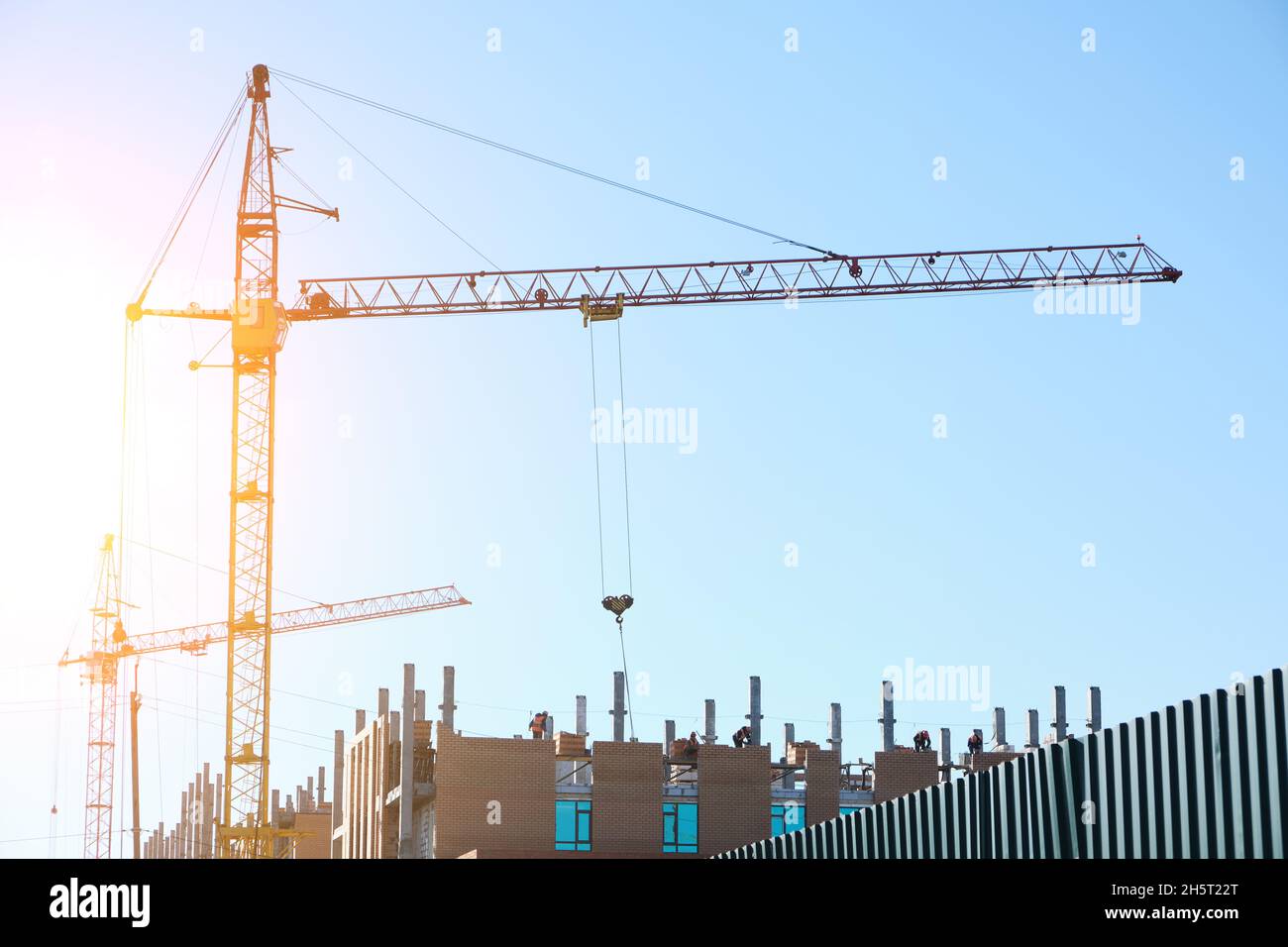 High rise construction crane on background of an unfinished multi ...