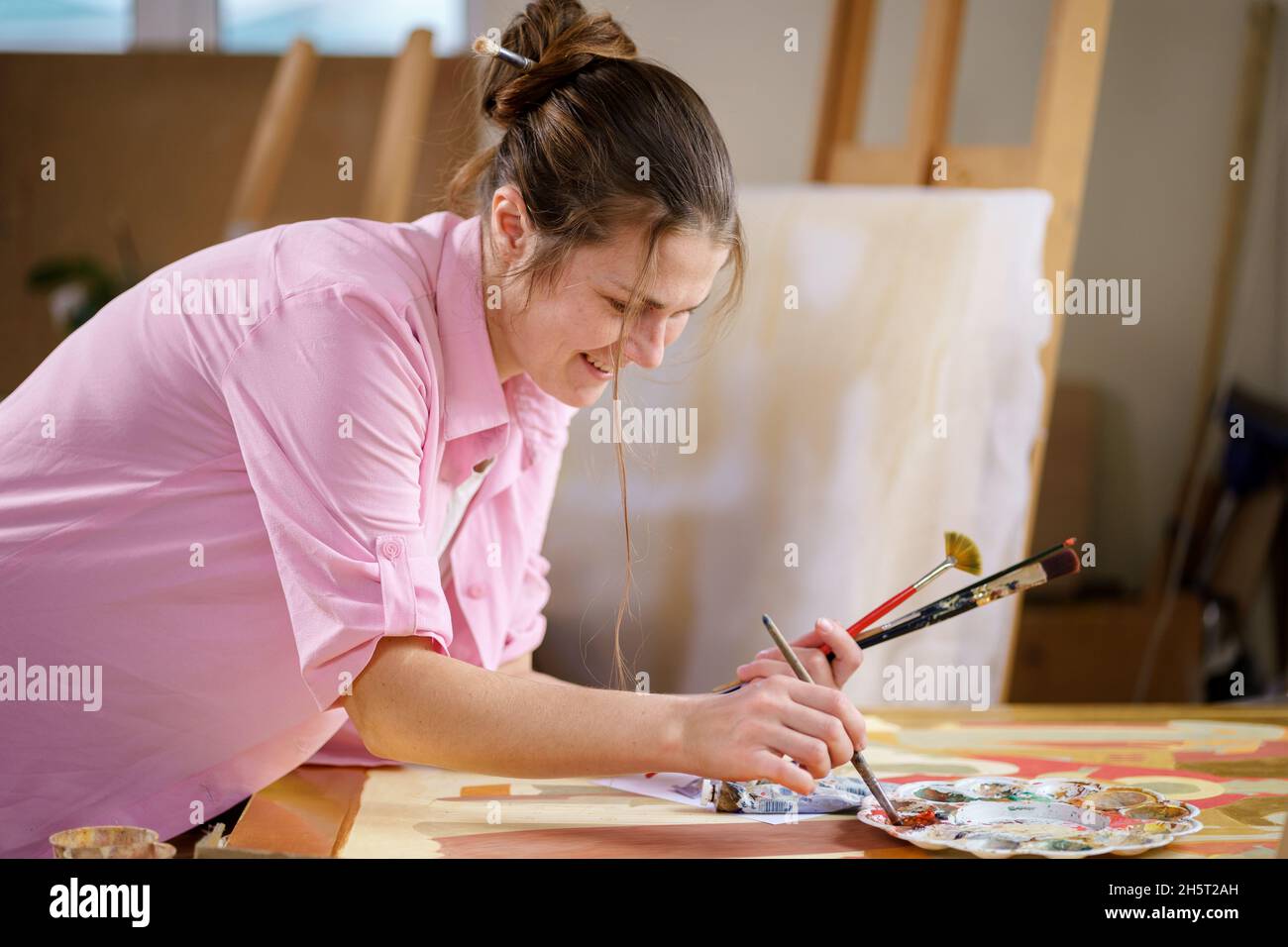 Female artist working in studio. Creative workspace, painting class ...