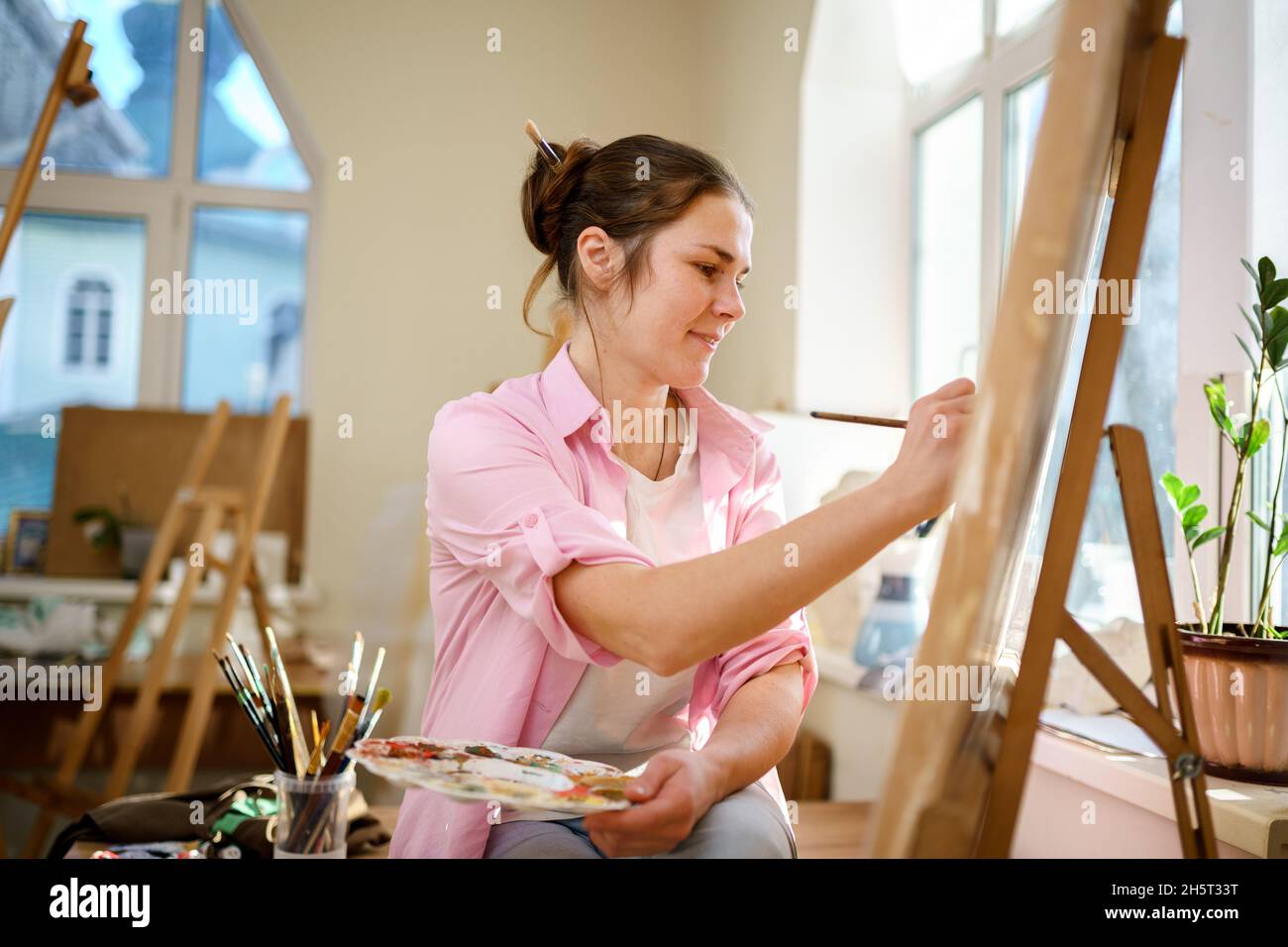 Female artist working in studio. Creative workspace, painting class ...