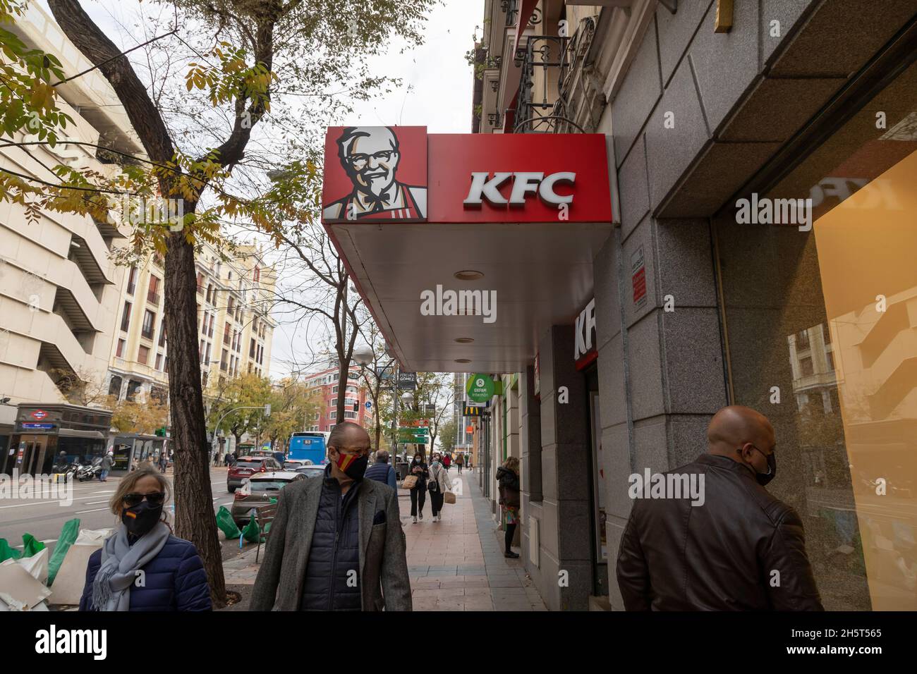 Madrid, Spain - Nov 25, 2020: Several people walk in front of the fast ...