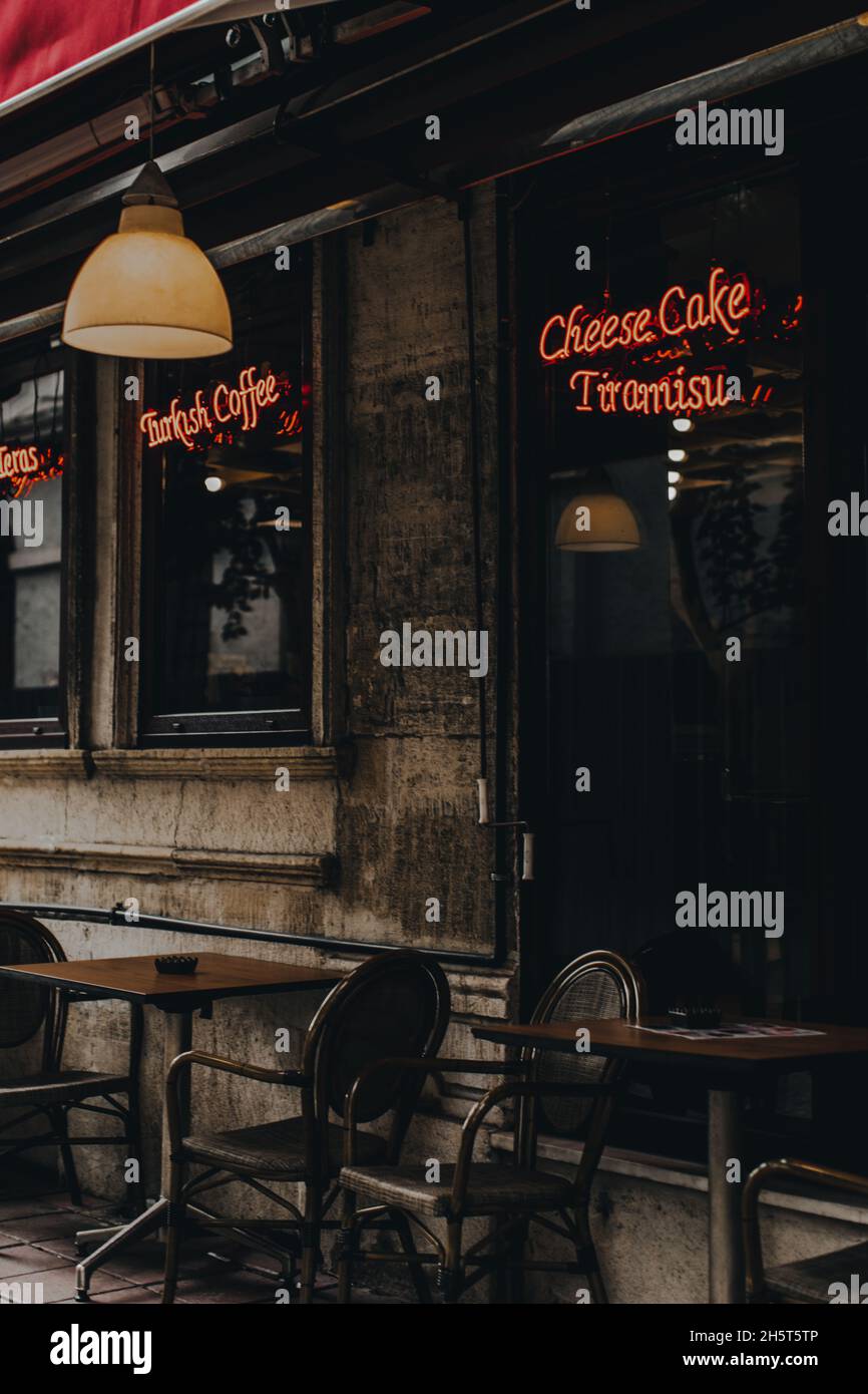 Exterior and veranda of a cozy Turkish cafe with brown wooden tables ...