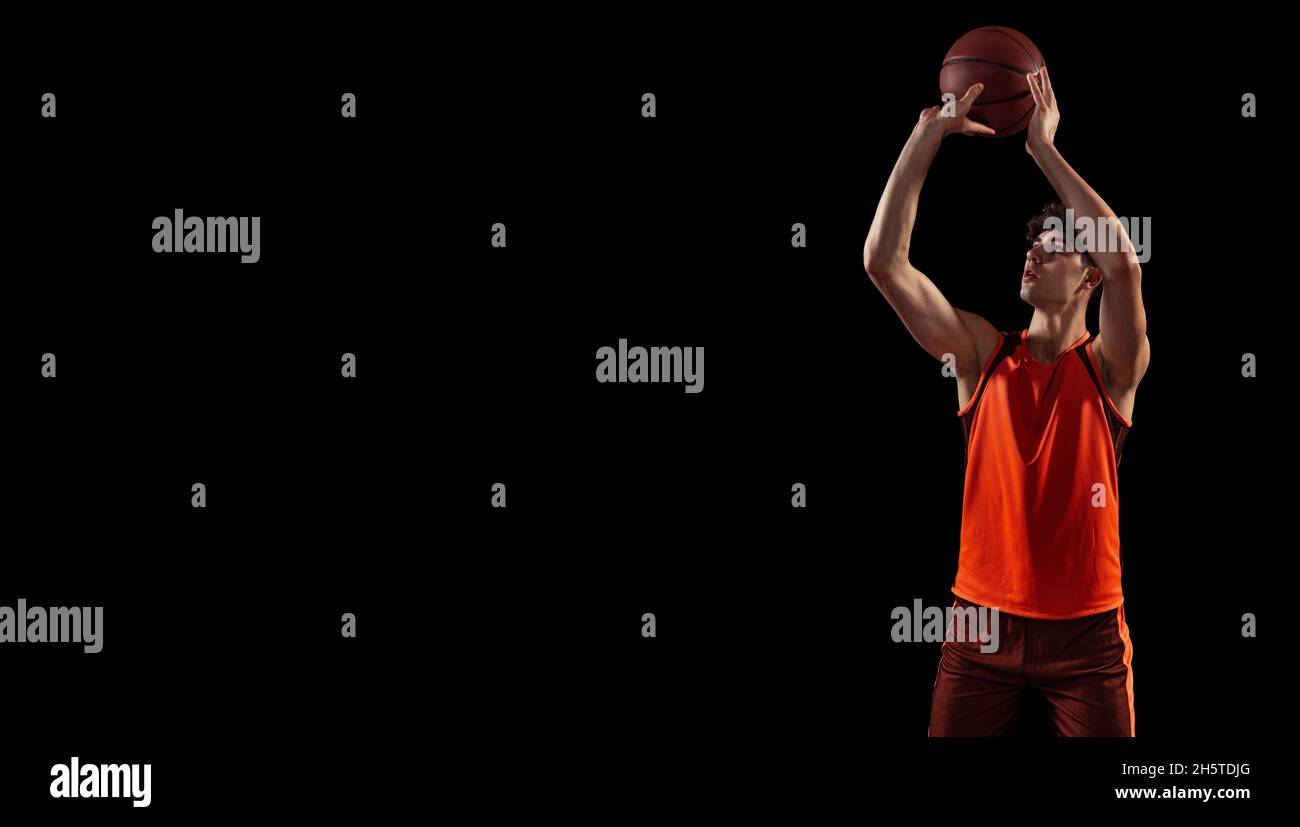 Studio shot of young man, basketball player doing set shot isolated on ...
