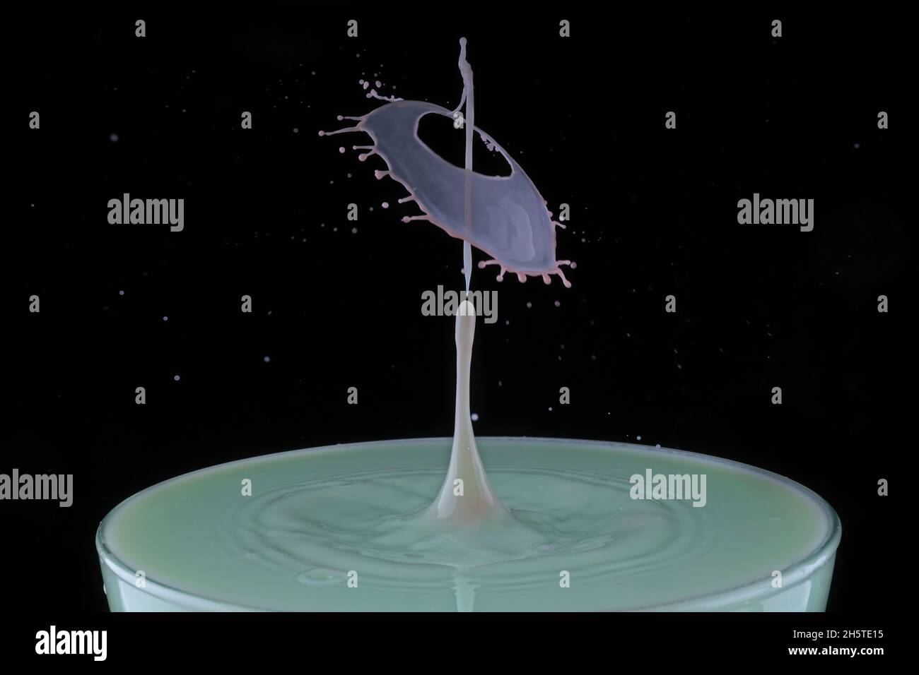 A drop of milk falls into a cup Stock Photo - Alamy