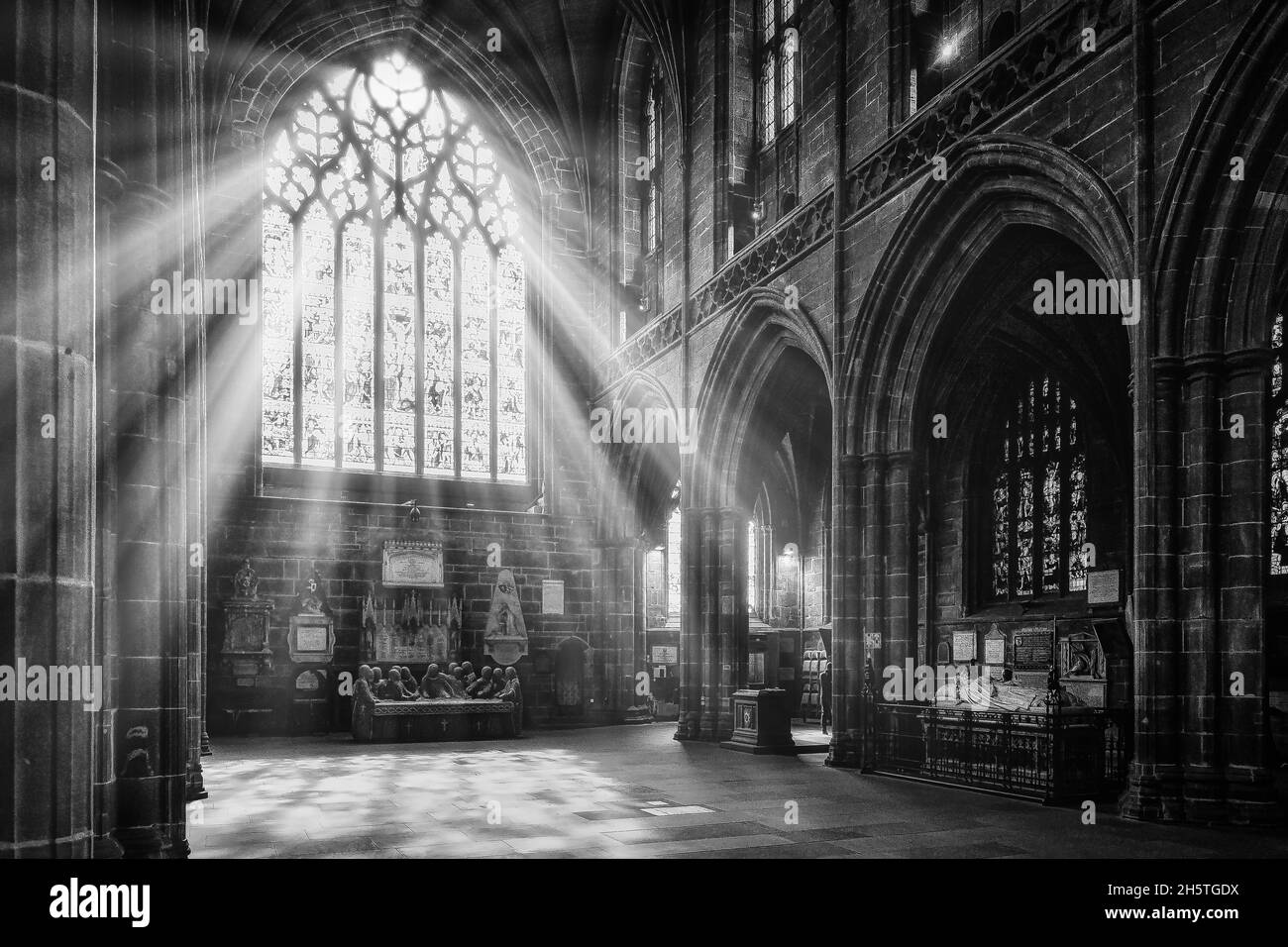 a large cathedral with sun rays coming through a stained glass window ...