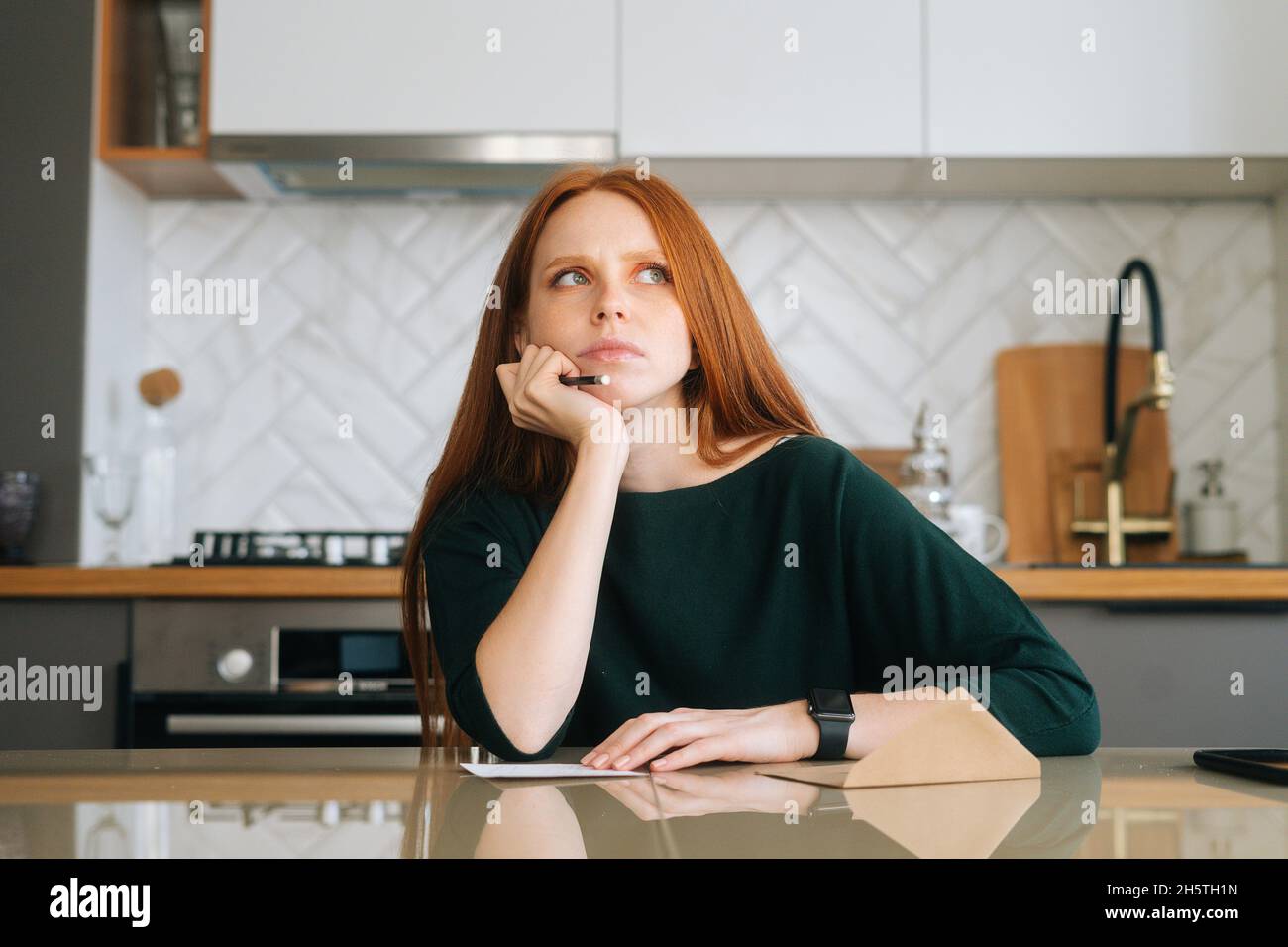 Front view of confused young woman writing handwritten letter sitting ...