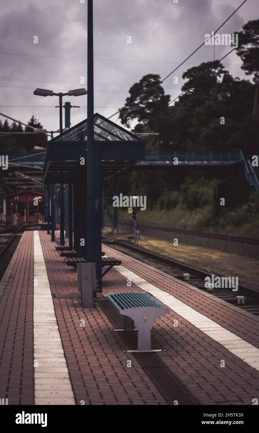 Vertical closeup of a Train path at the station with benches under the ...