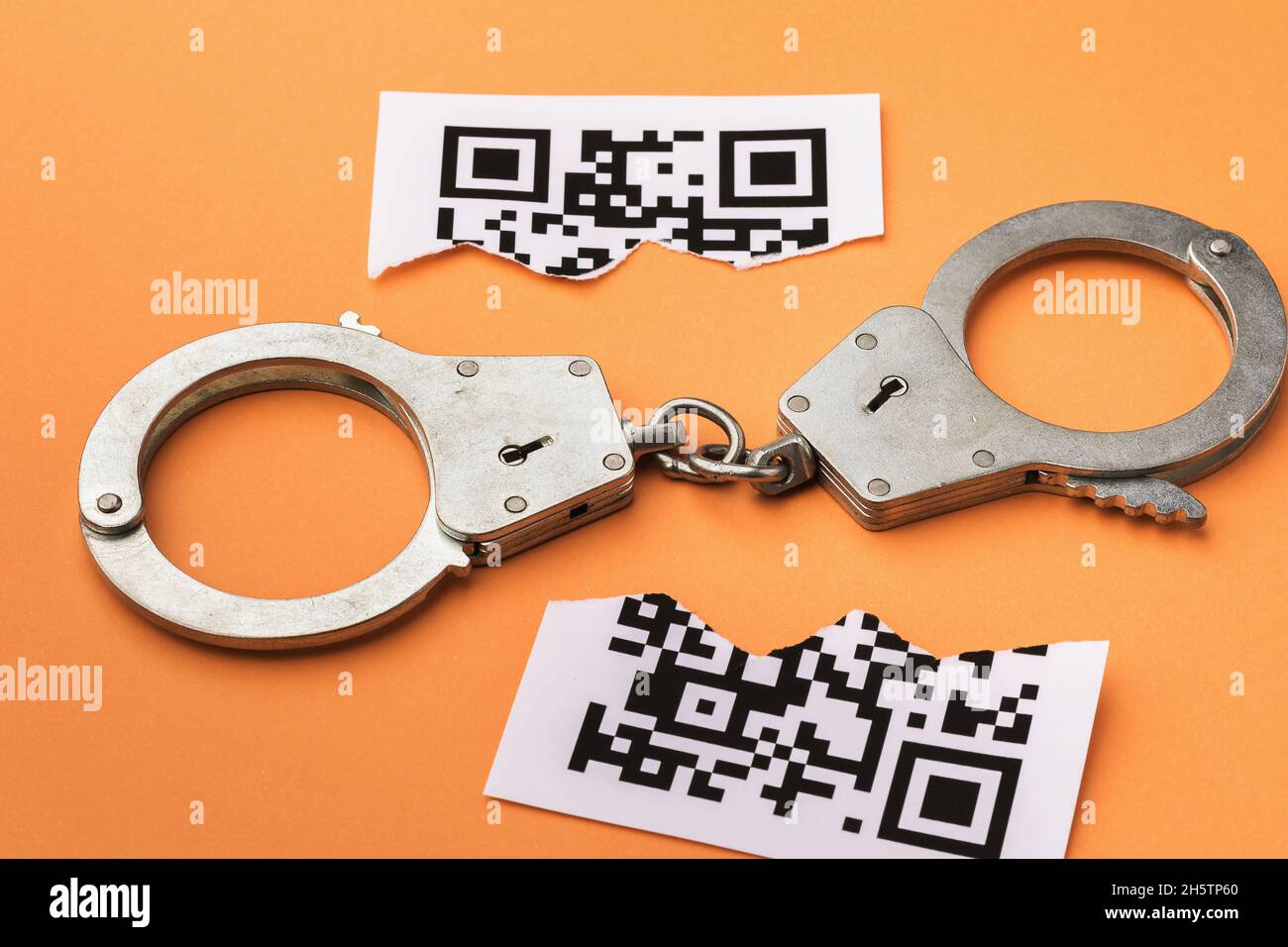Handcuffs and a torn sheet with a barcode on a colored background, the ...