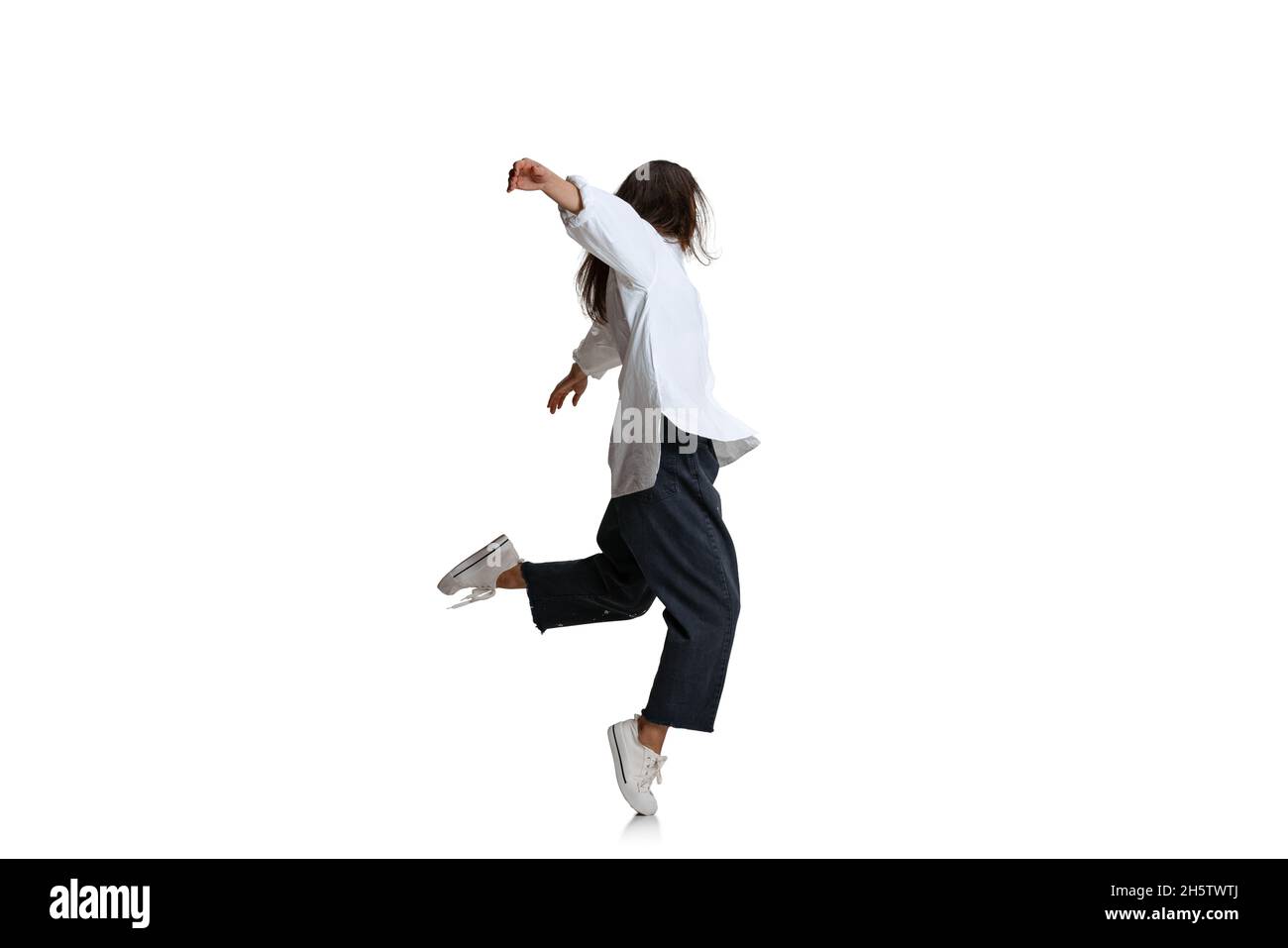 One pretty woman in casual wear dancing isolated on white background ...