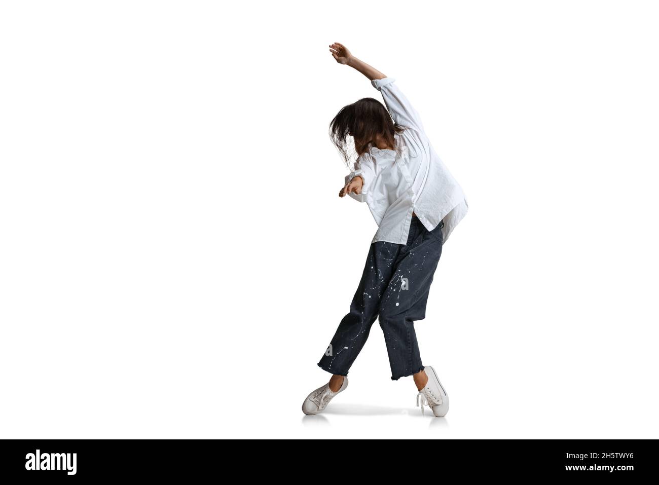 One pretty woman in casual wear dancing isolated on white background ...