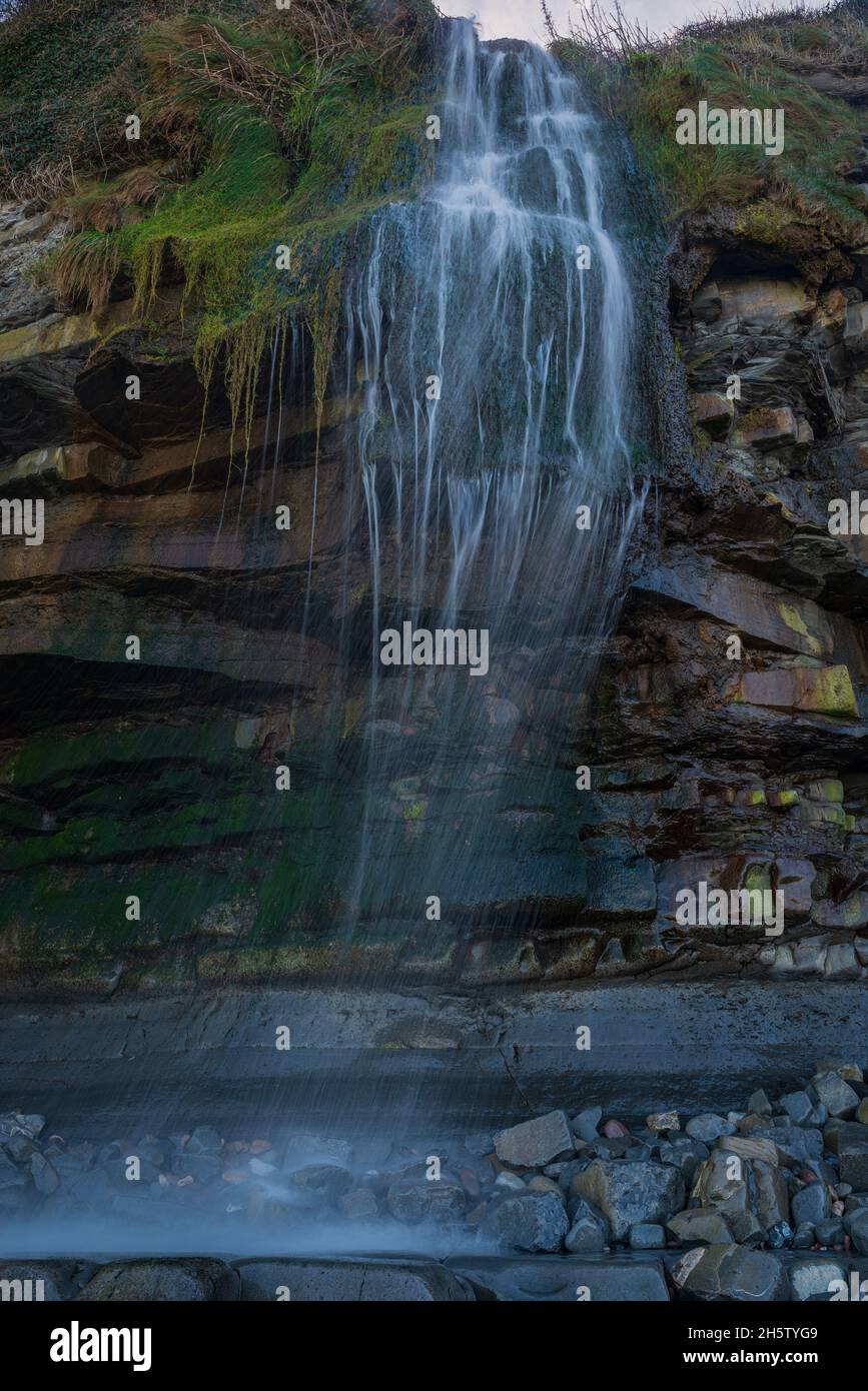 Cliffs and rock strata visible at low tide on the beach at East ...