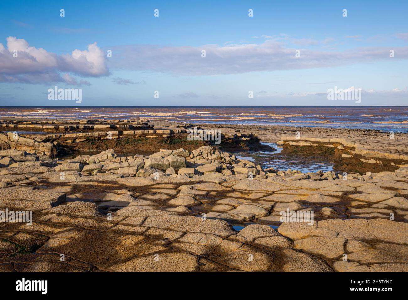 Cliffs and rock strata visible at low tide on the beach at East ...
