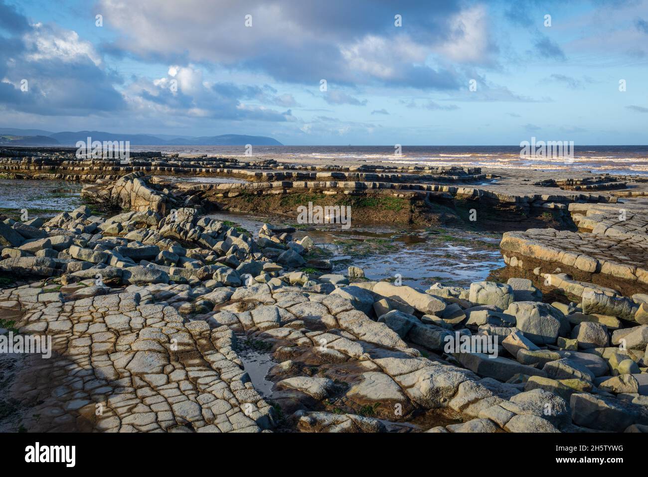 Cliffs and rock strata visible at low tide on the beach at East ...