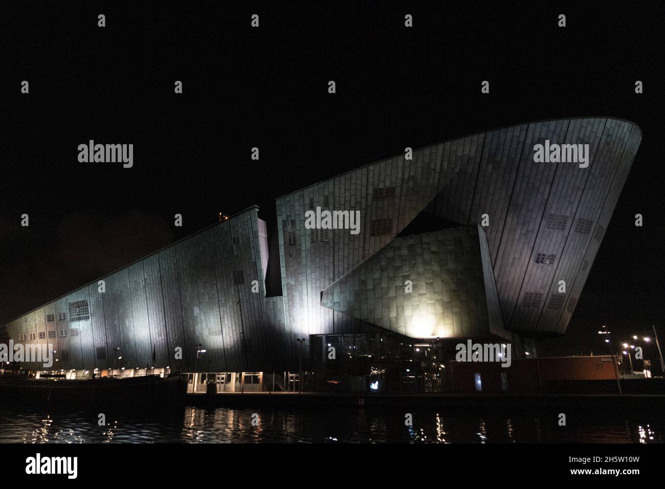 Amsterdam NEMO museum at night canal view cityscape Stock Photo - Alamy