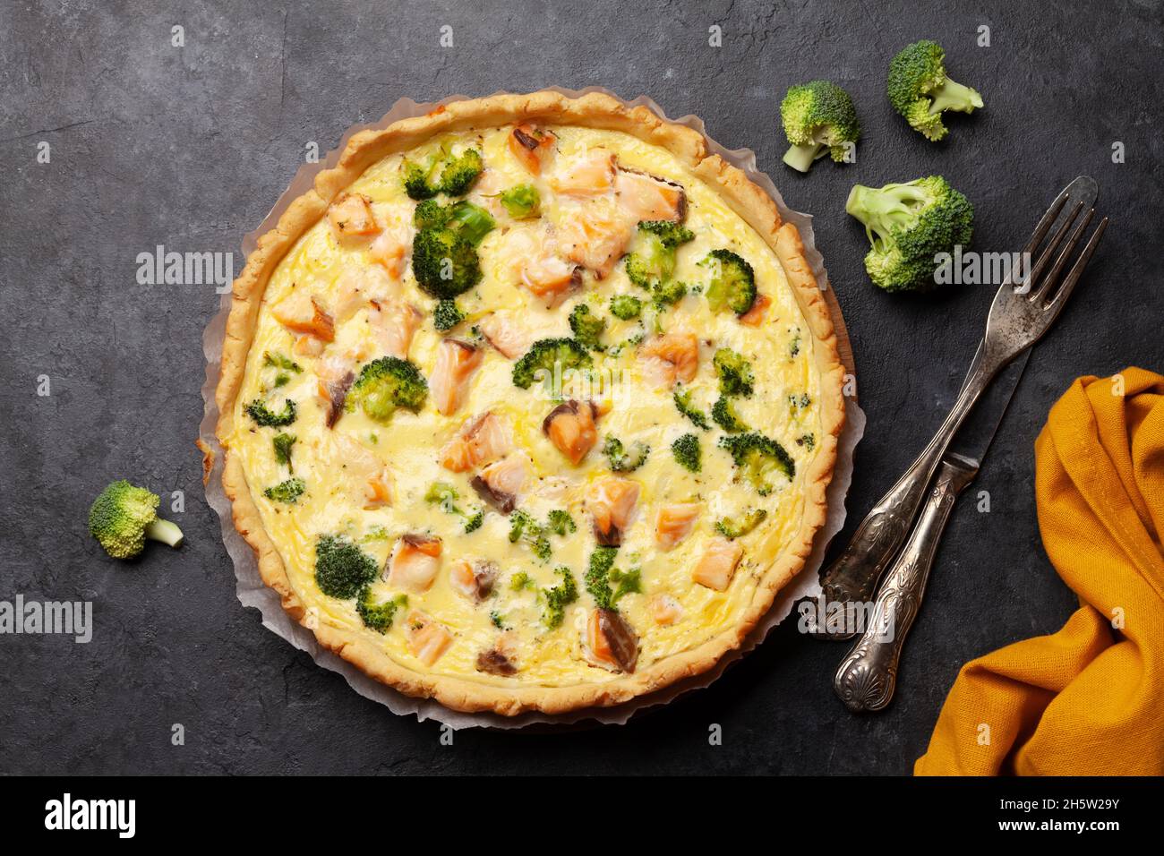 Homemade fish pie. Open faced salmon and broccoli pie on dark kitchen ...