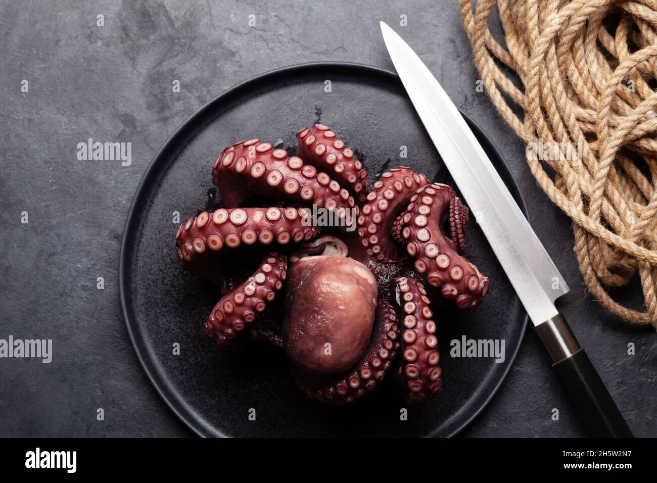 Tasty octopus on black background. Top view flat lay Stock Photo - Alamy