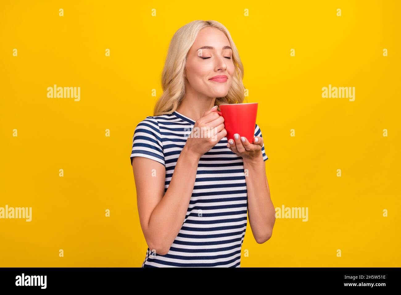 Portrait of attractive dreamy cheerful girl drinking smelling latte ...