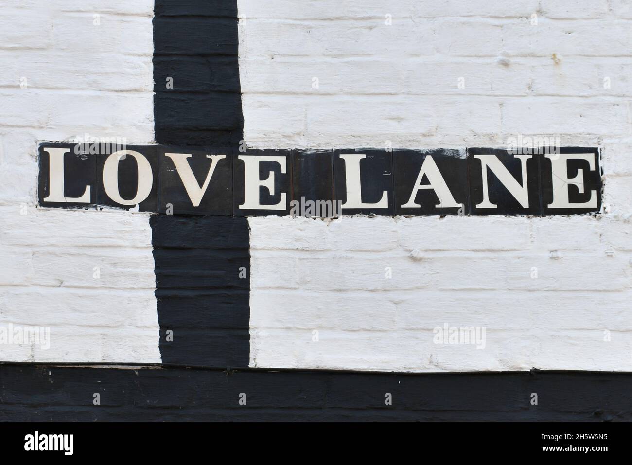 close up of street sign with text "Love Lane" on a black and white ...