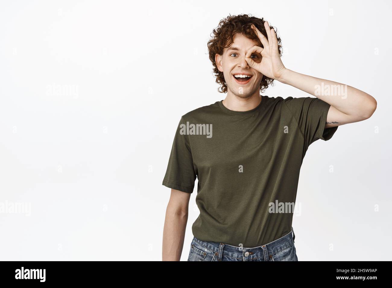 Happy teen guy showing ok sign, looking through okay, zero gesture and ...