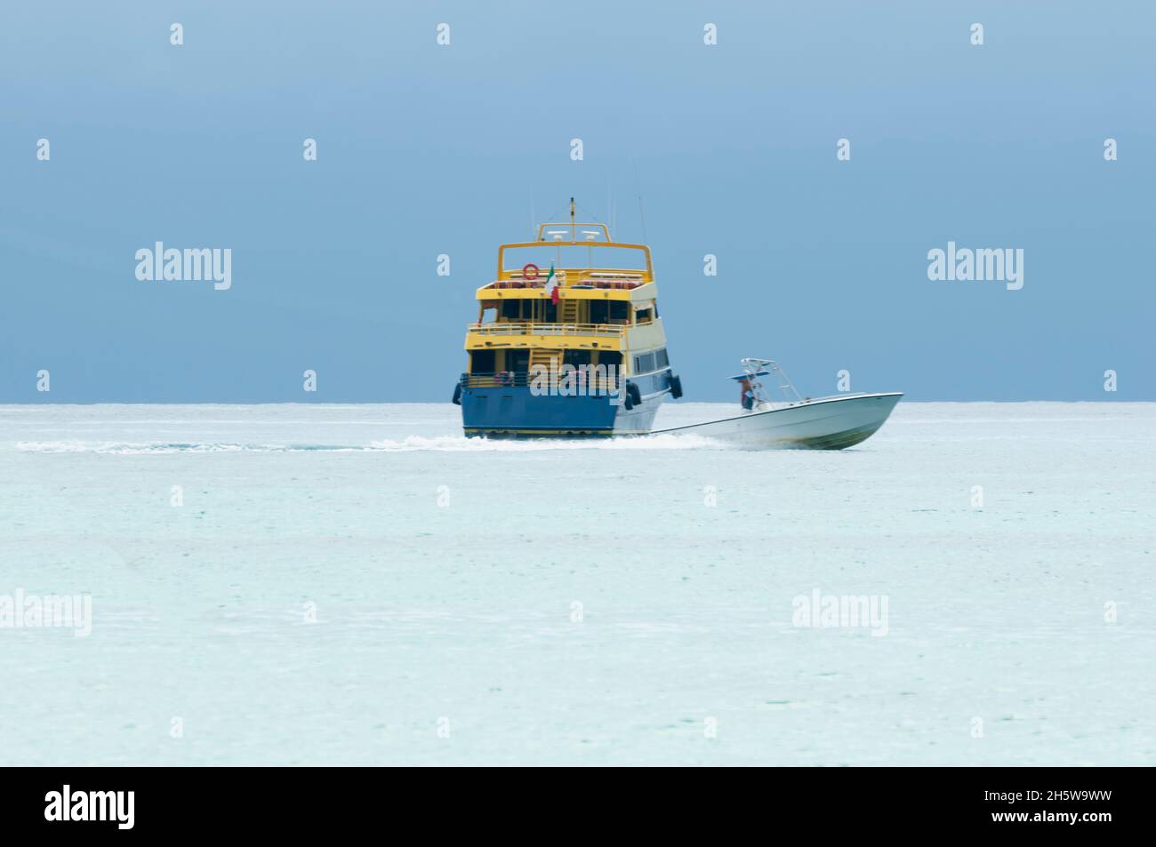 A Ferry and a small speedboat cross over the Caribbean Sea on the ...