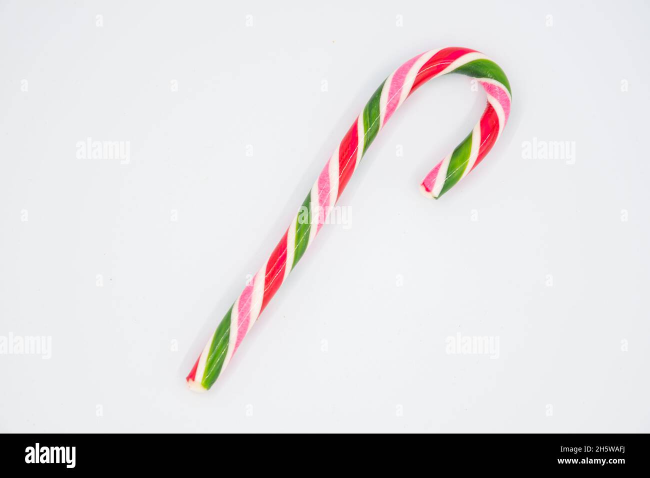 Festive Christmas treat. Flat lay of striped red candy cane isolated on ...