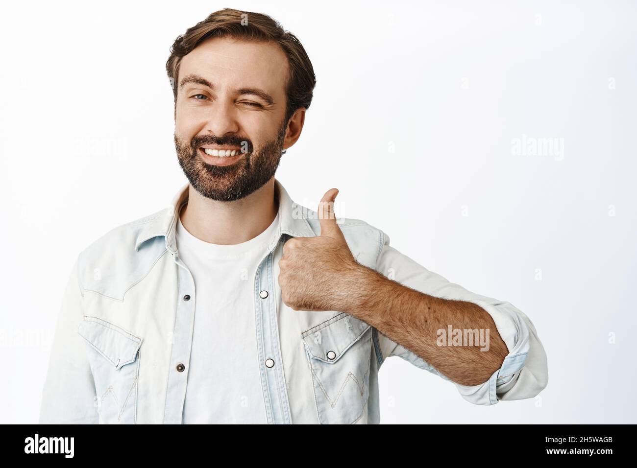 Cheerful caucasian male model with long beard, winking and showing ...