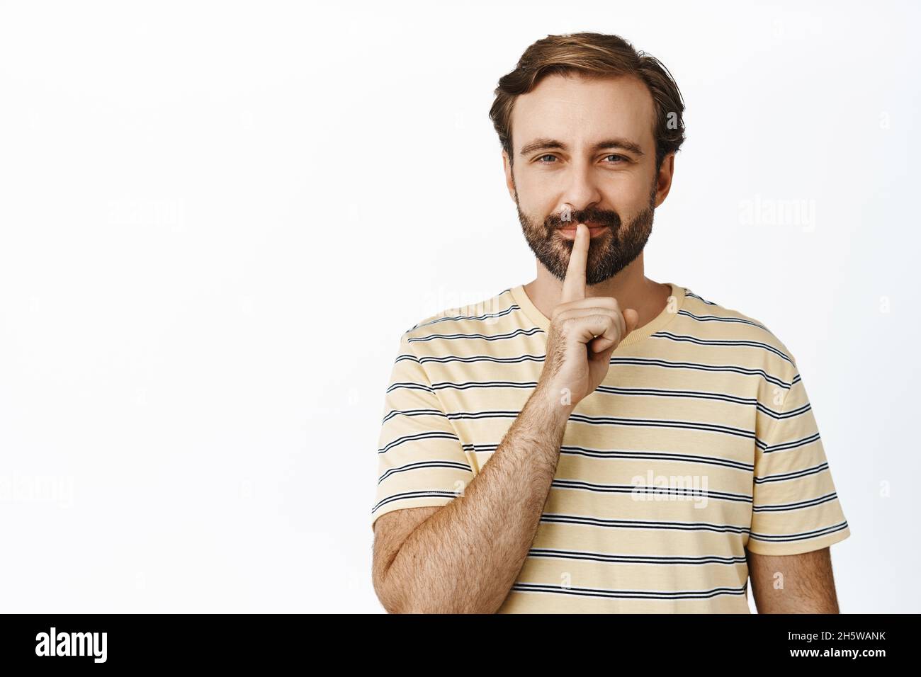 Its a secret. Smiling coy guy showing shush, taboo hush gesture ...