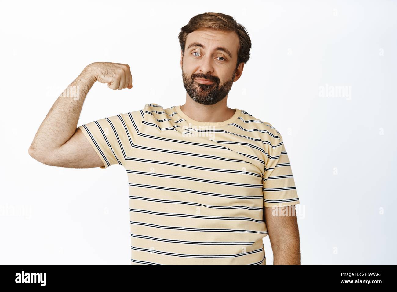 Funny bearded guy shows his biceps, flexing muscles on arms and looking ...