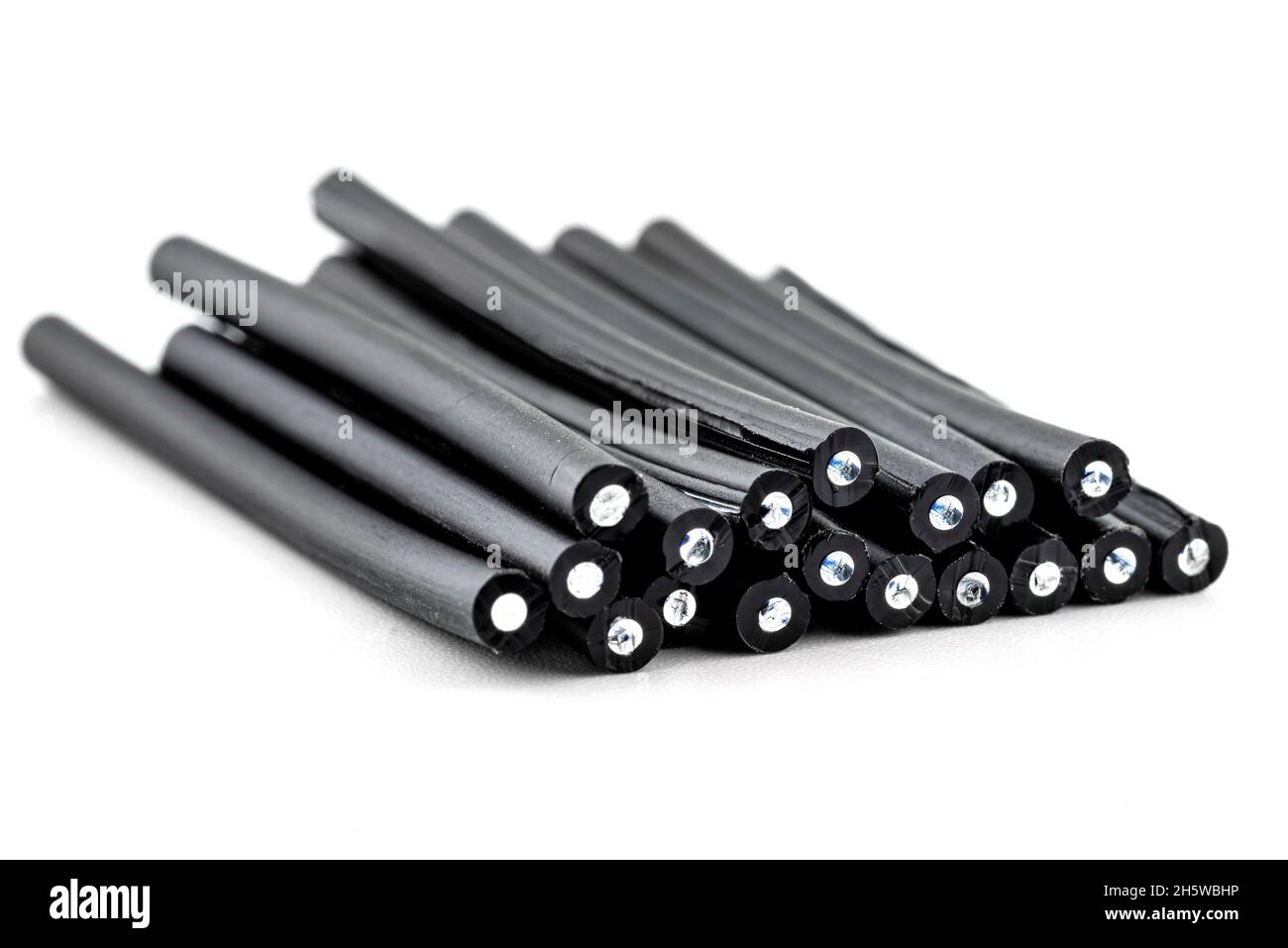 A stack of cut fiber optic cables lying on top of each other, isolated ...